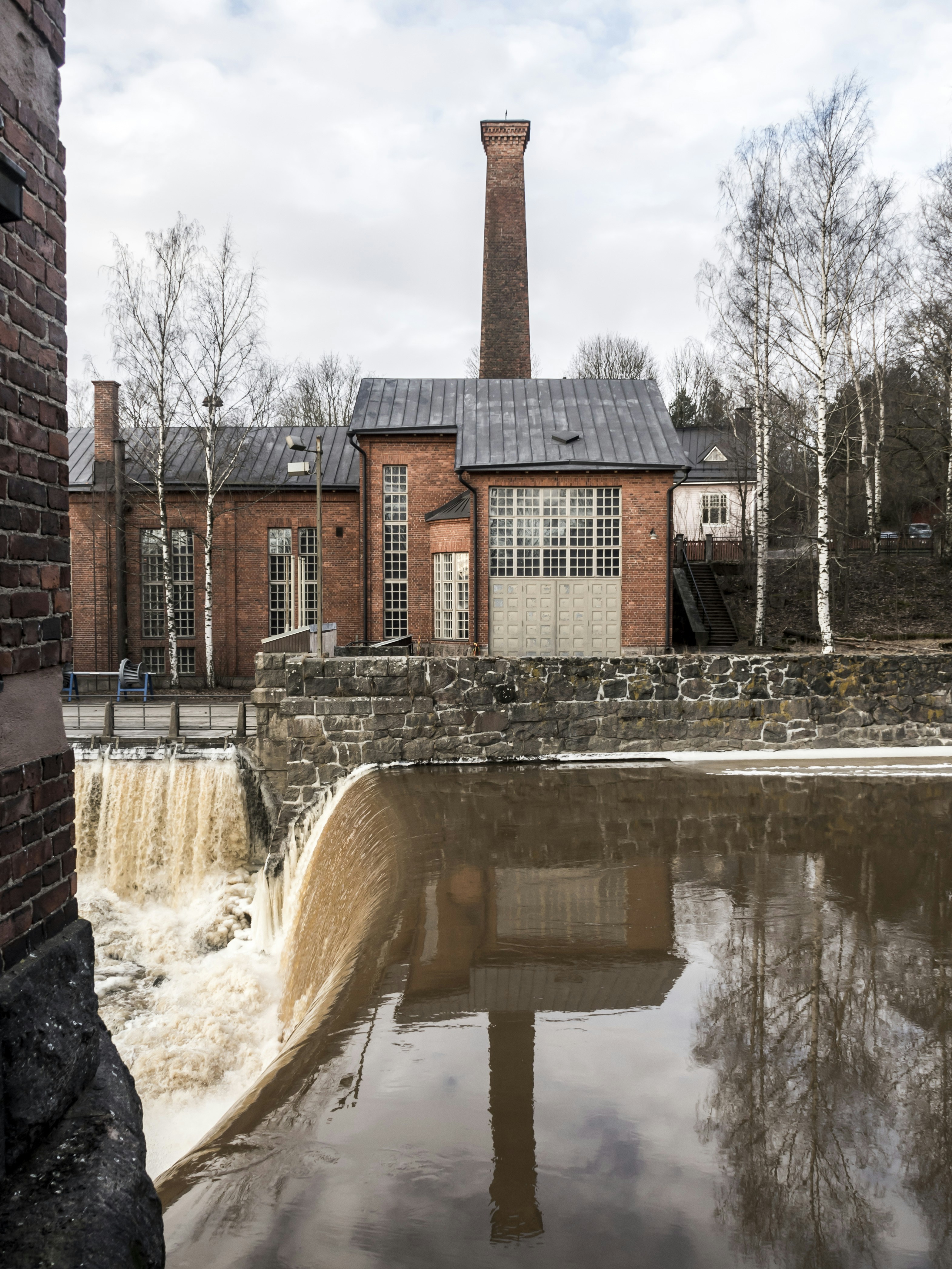 Brick Chimney Over a Riverside Weir: Echoes of Industry
