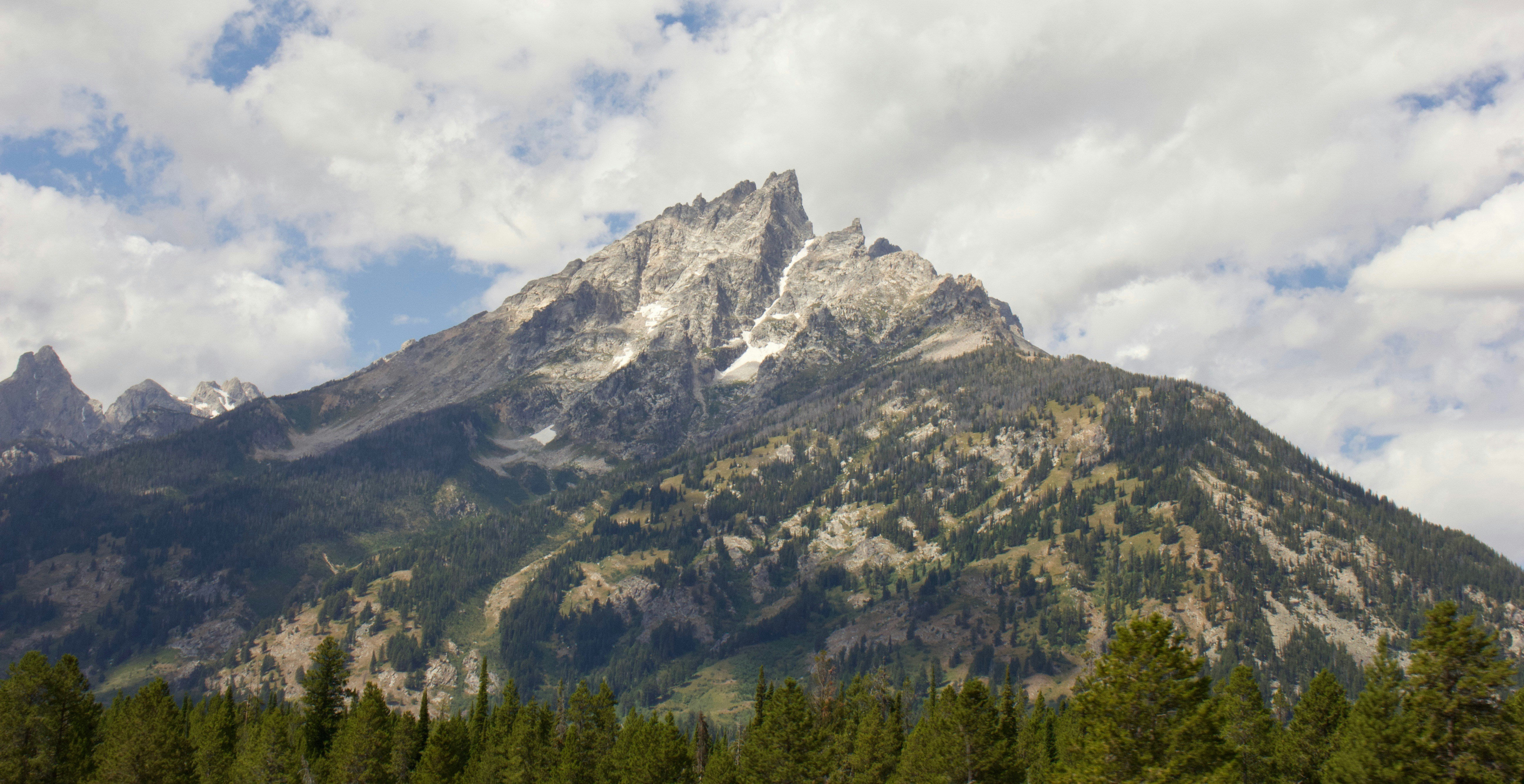 Snow-capped mountain range beneath a sky filled with dynamic clouds.