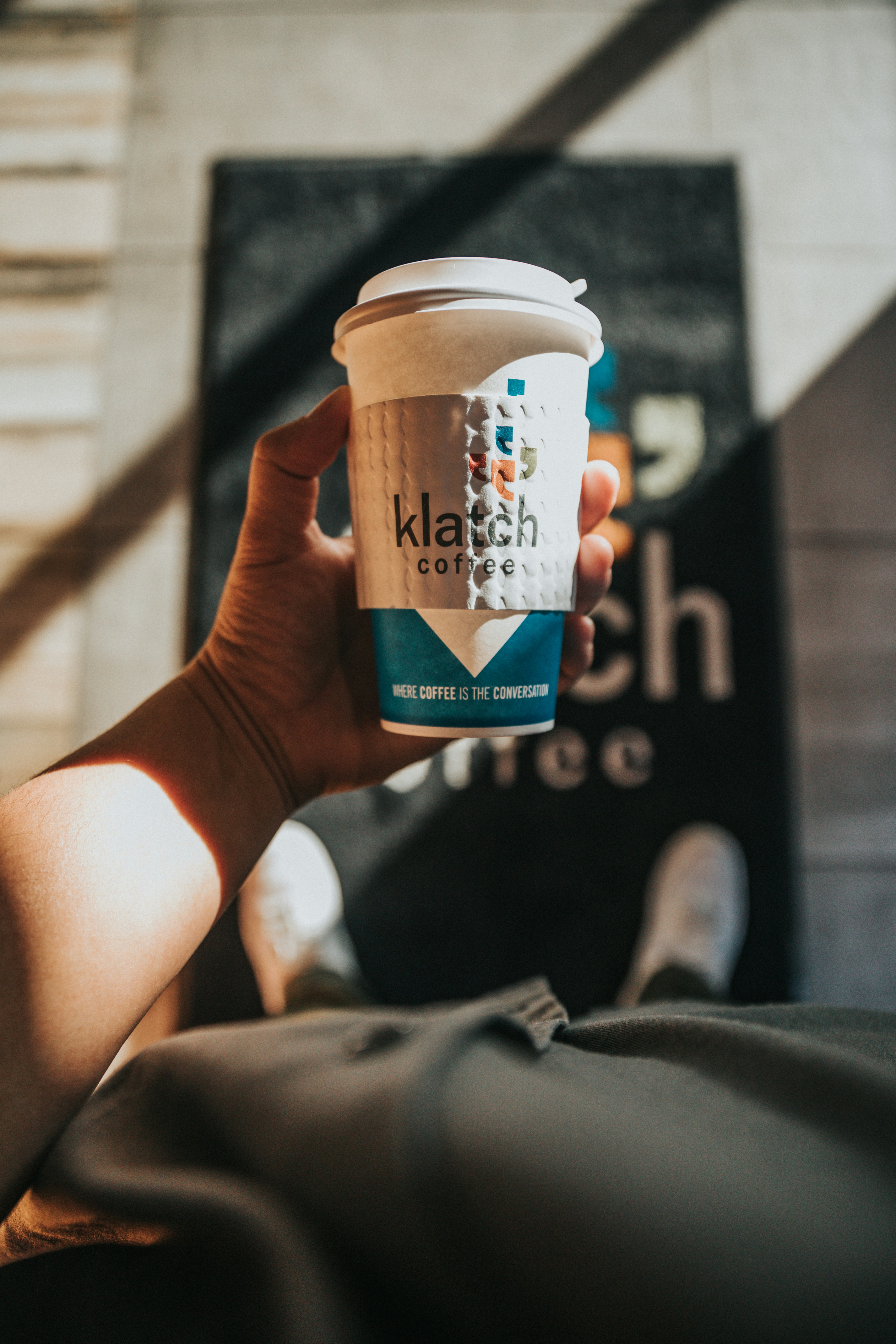 Cupless Moment: Hand-Held Coffee Lift in Urban Light