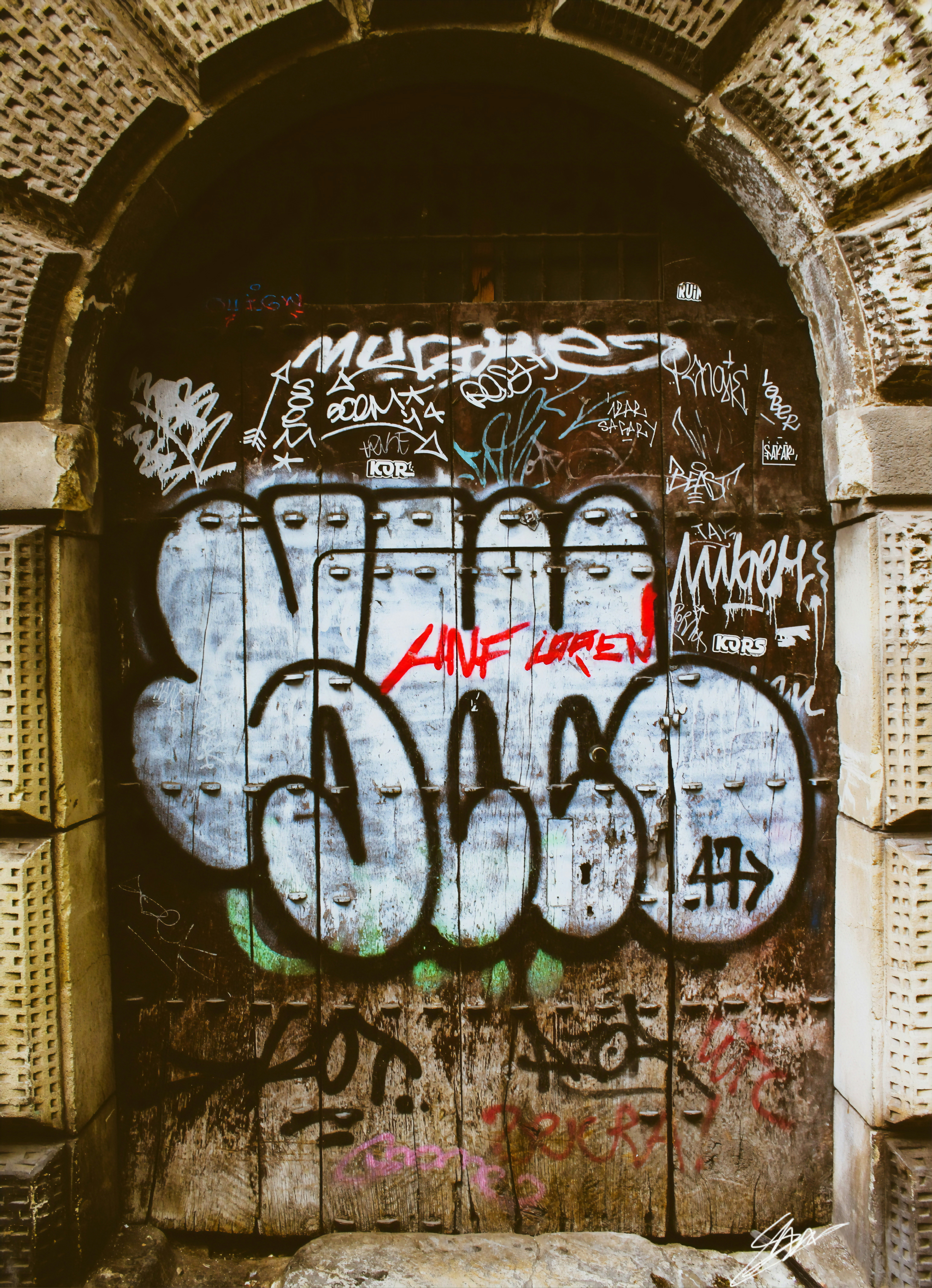Neon Blue Graffiti Gate Beneath a Timeworn Arch