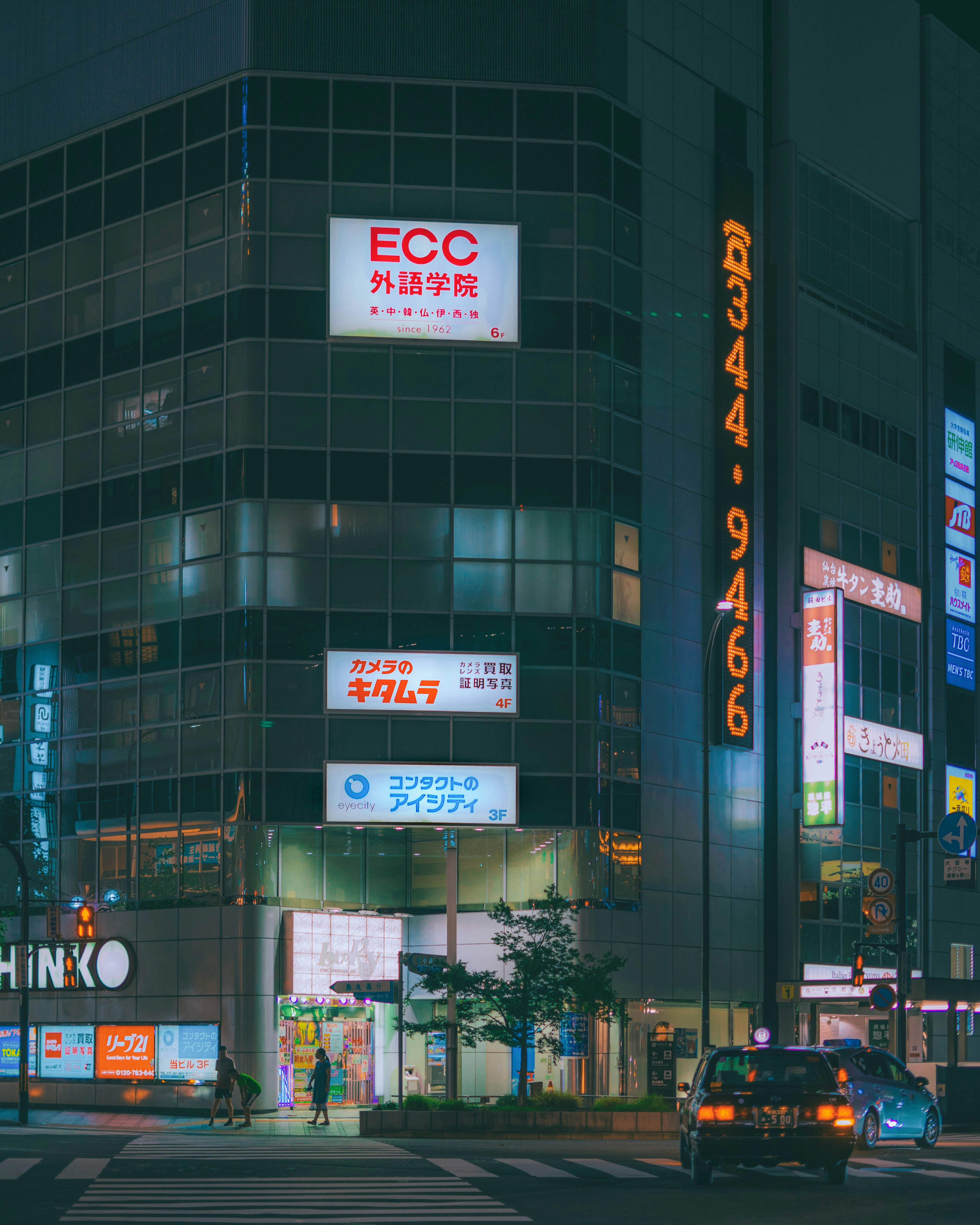 Neon Crossroads: Sign-Lit Glass Tower at Night