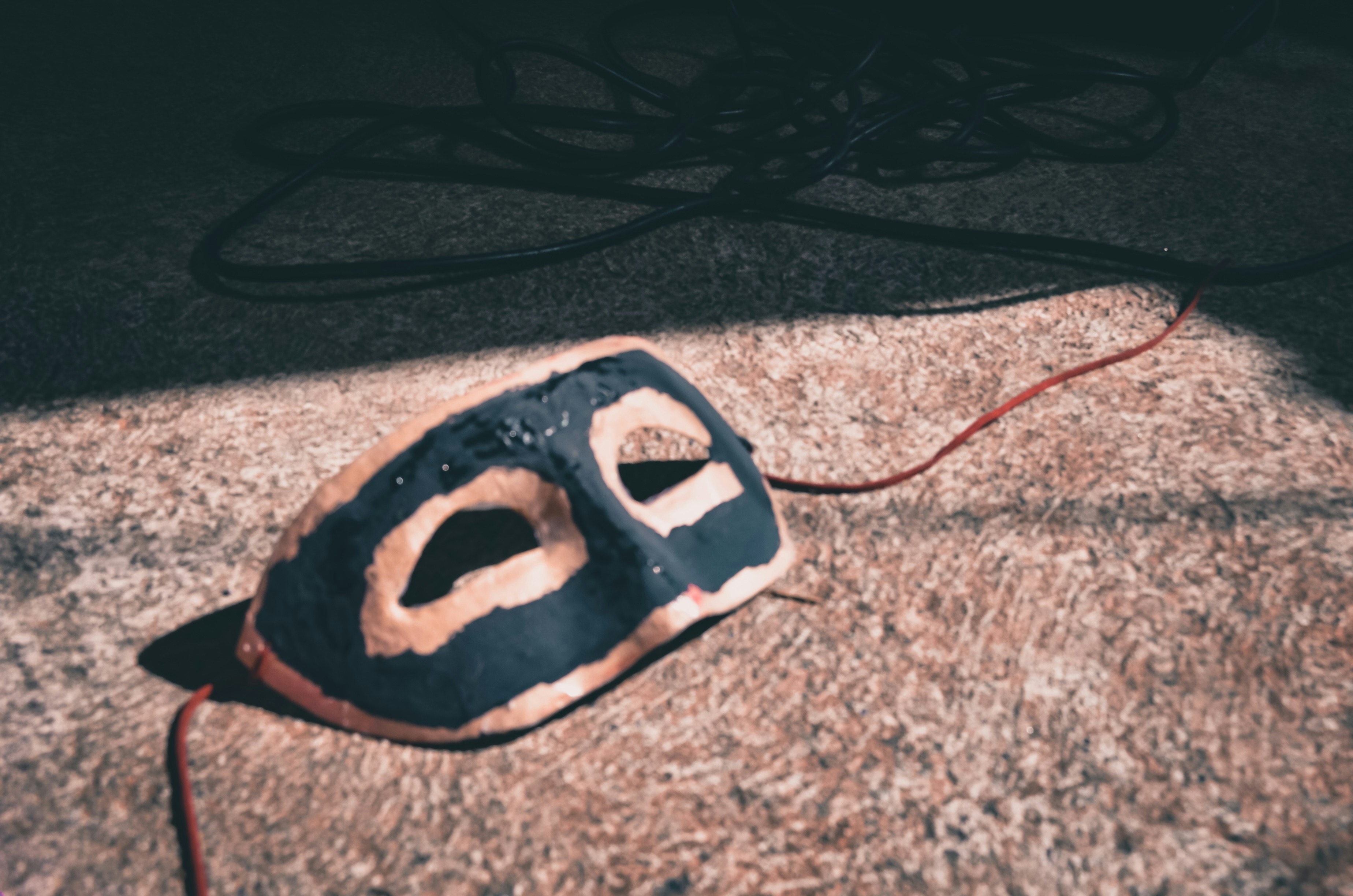 Concrete Spotlight: A Mask Forgotten on Sunlit Pavement