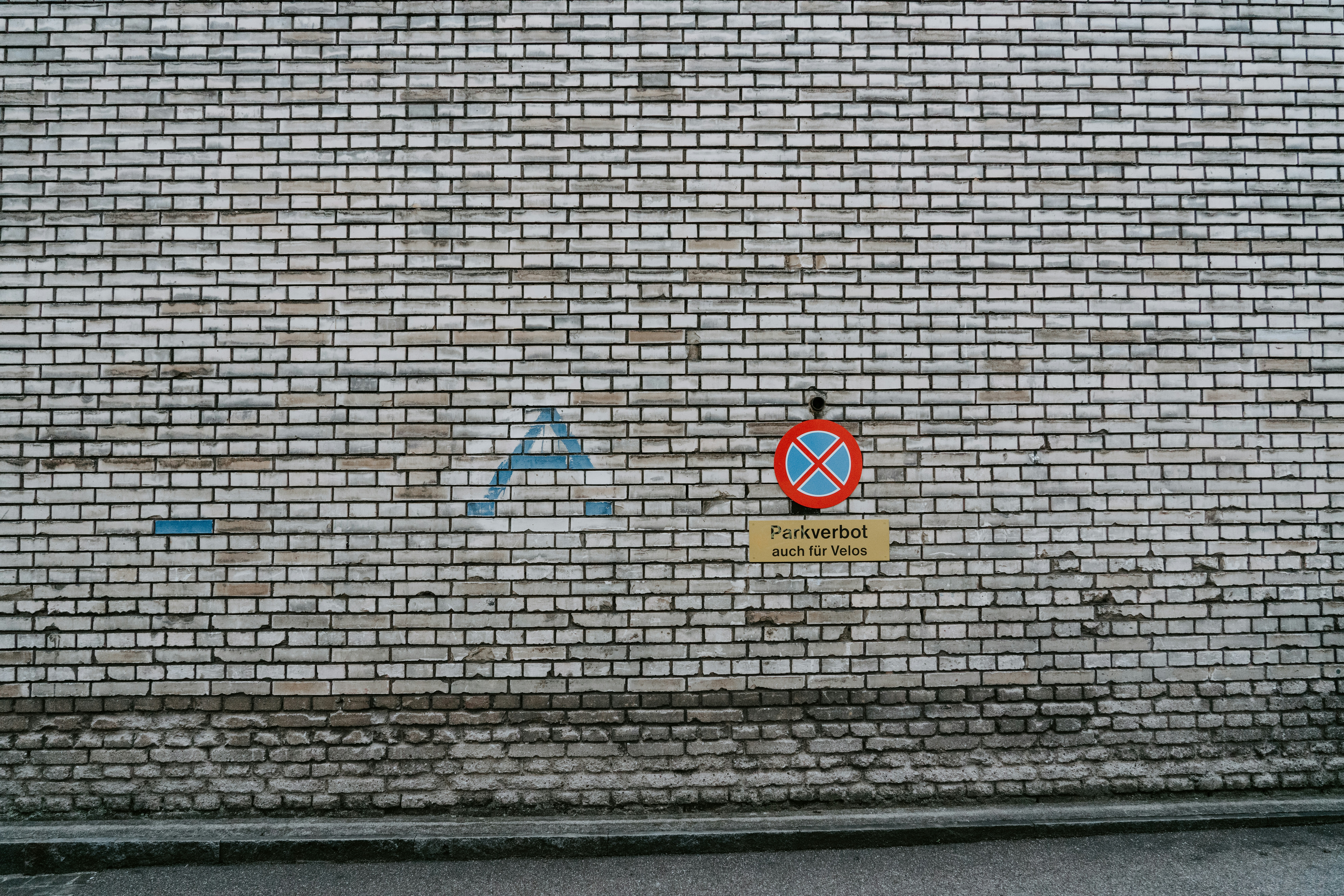 No-Parking Sign on a Weathered Brick Canvas