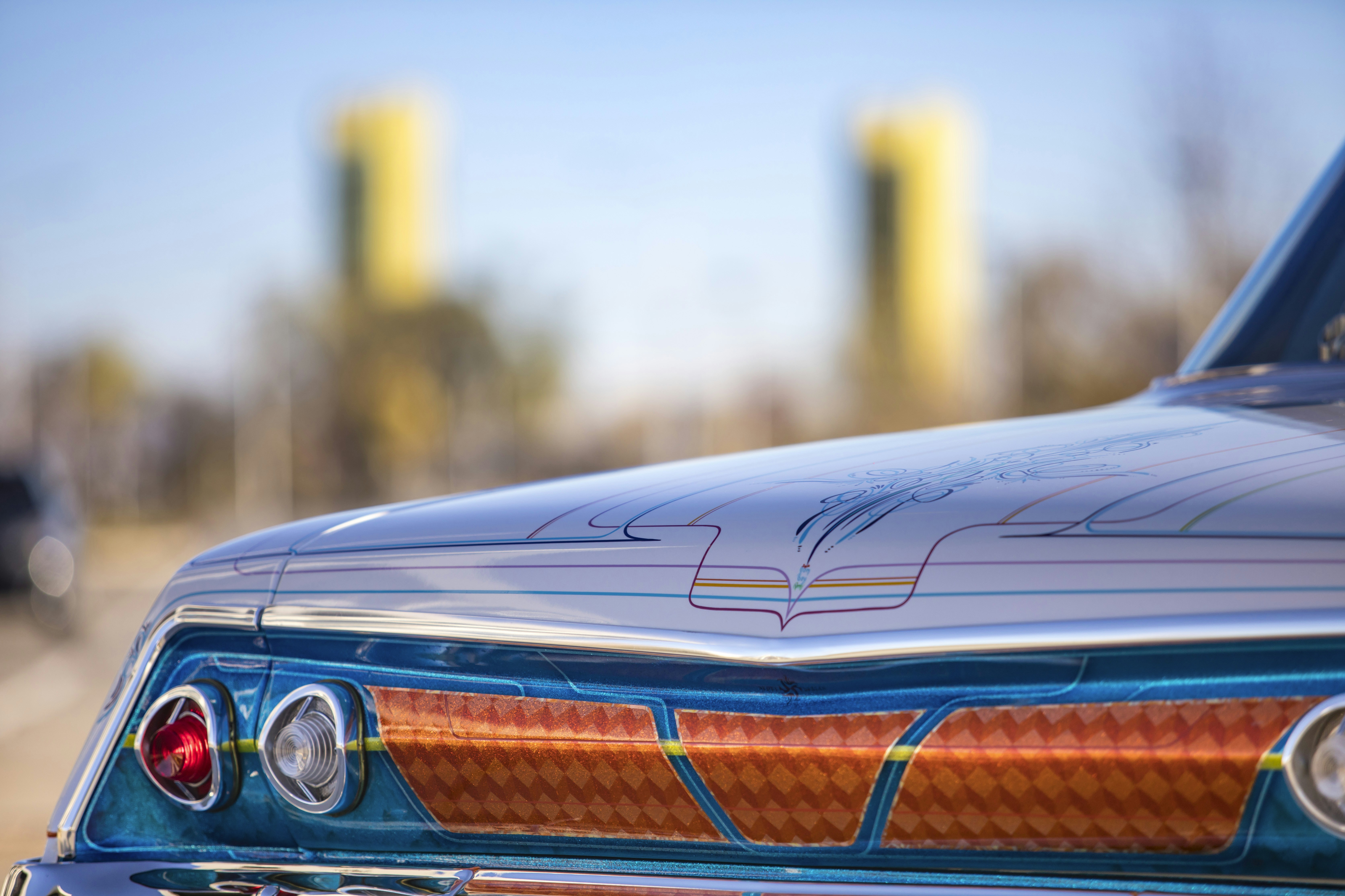 Sunlit Chrome and Blues: Close-Up of a Classic Car Hood