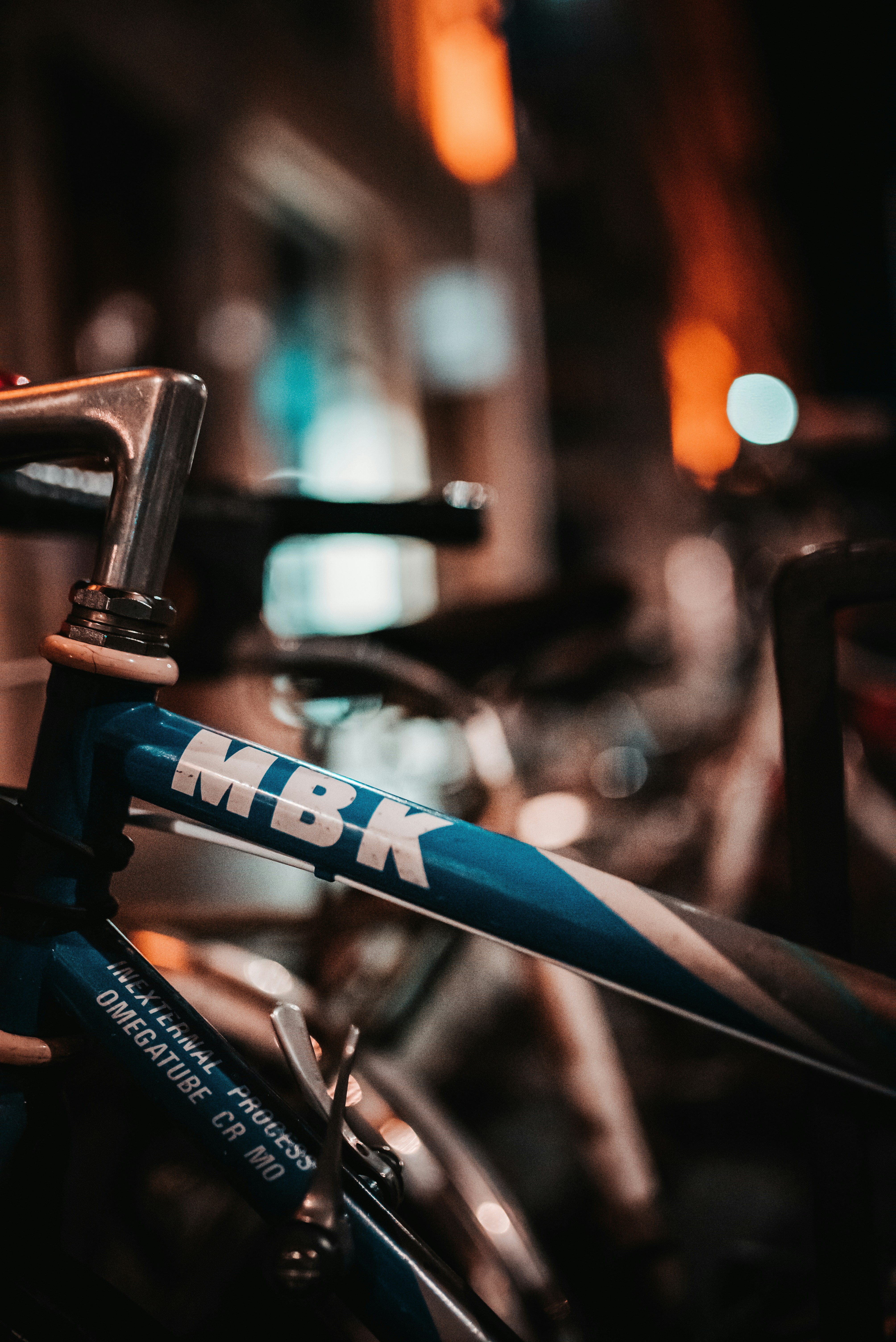 Blue Bicycle Frame in Night Street – Neon Bokeh and Focused Details