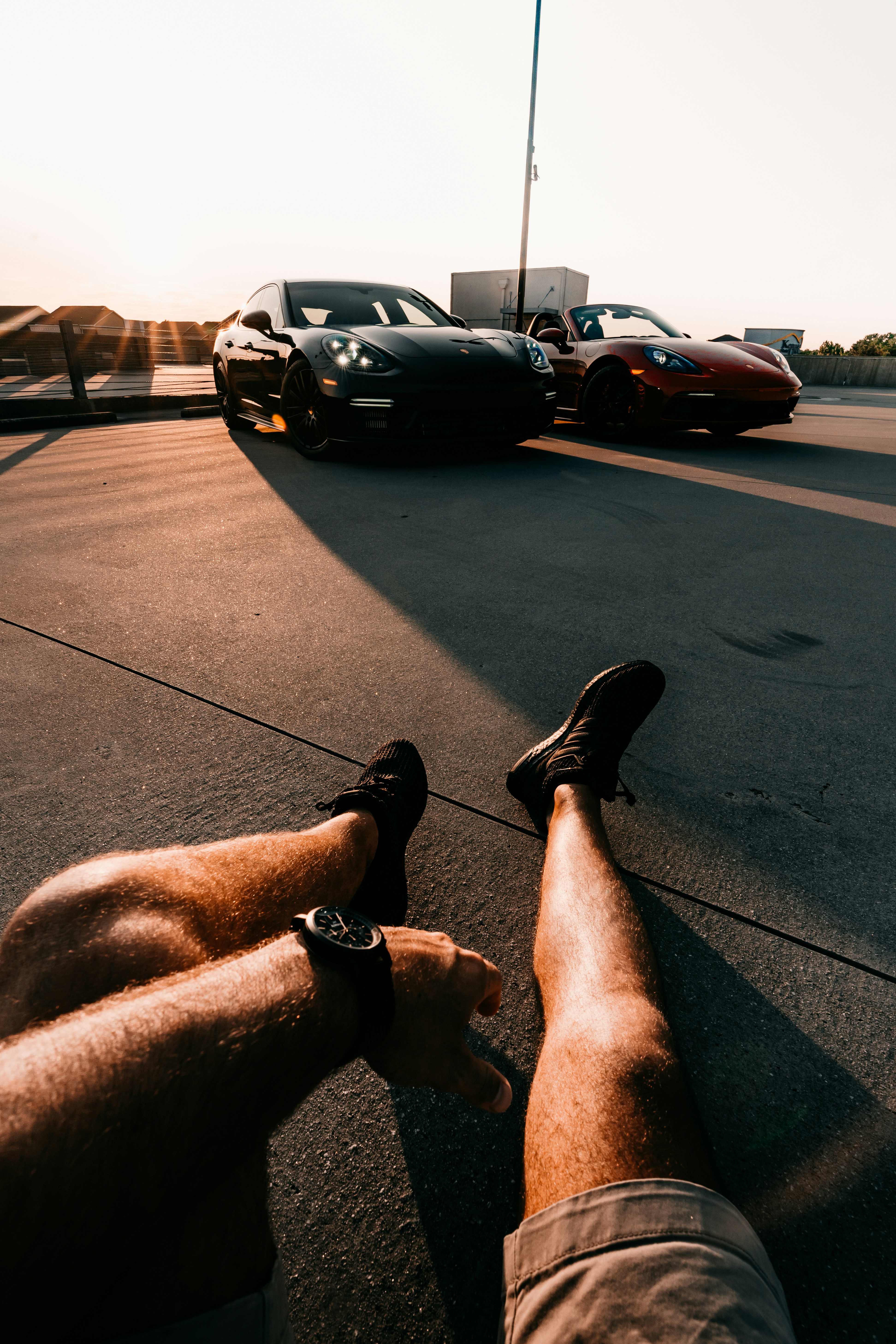Rooftop Rally at Dusk: A Ground-Level Gaze at Black and Red Sports Cars