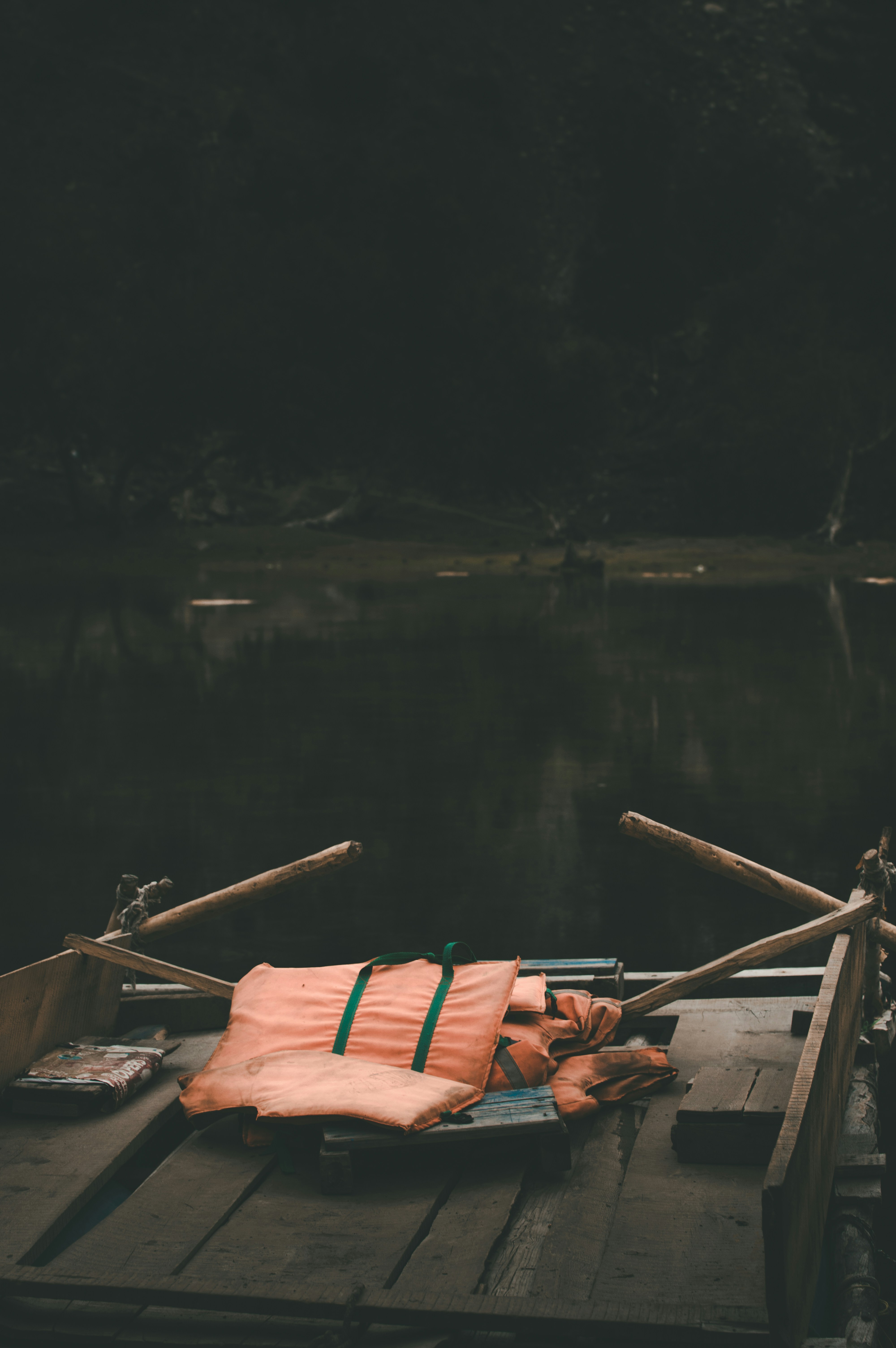 person lying on brown wooden boat on lake during daytime