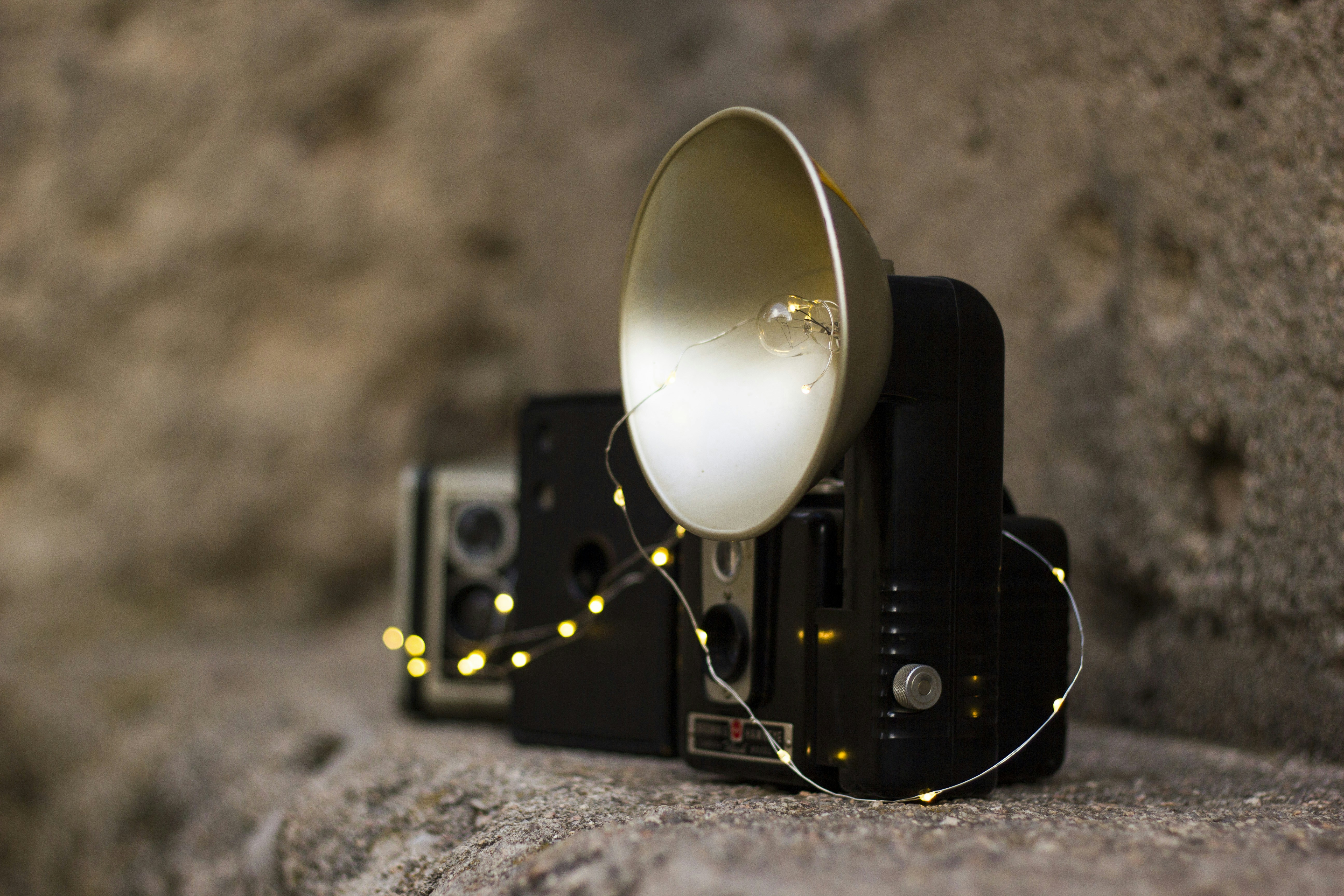 Fairy-Lit Relic: A Vintage Camera Under a Dish Spotlight