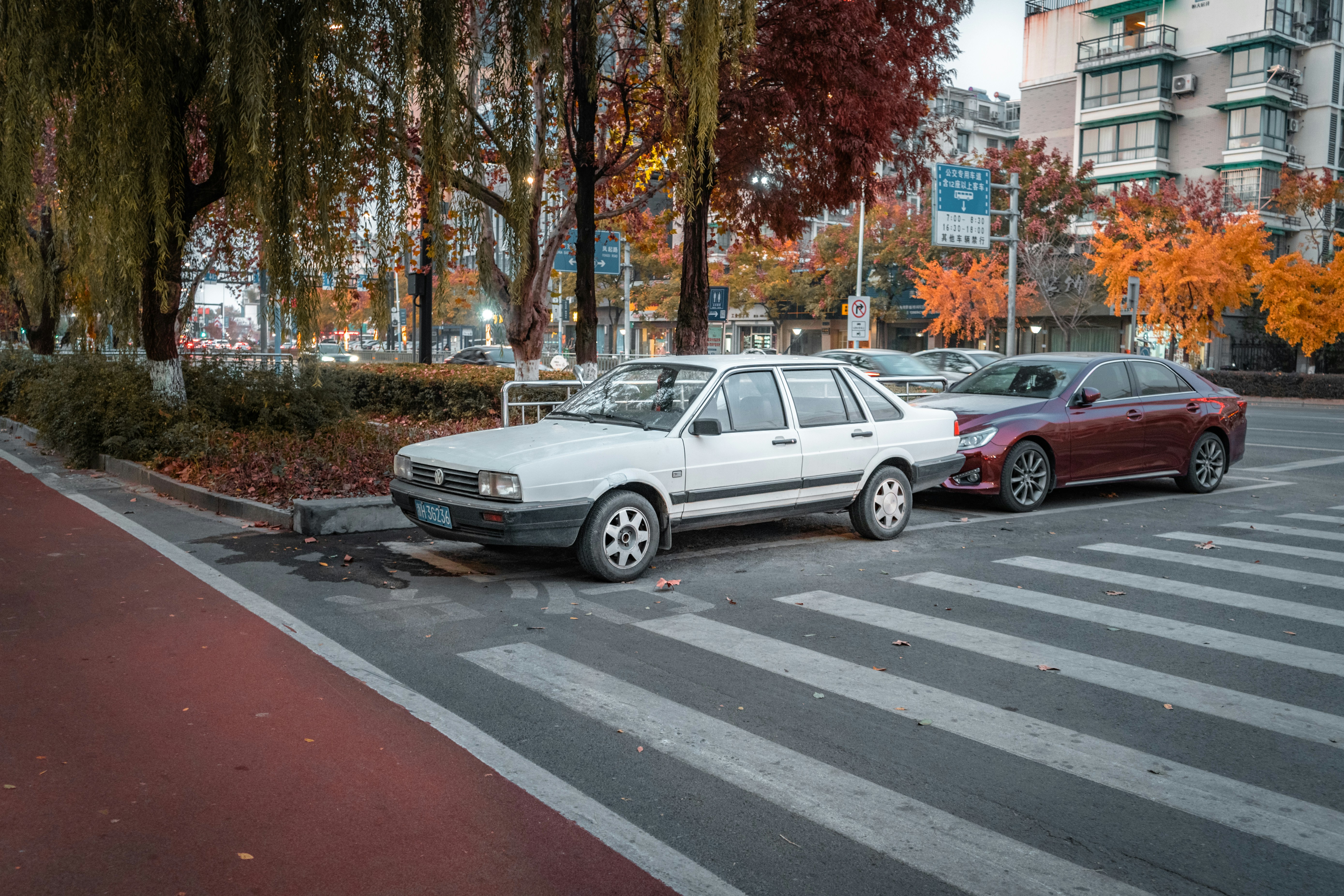 A Quiet Street Intersection: Silver Sedan Meets Autumn Colors