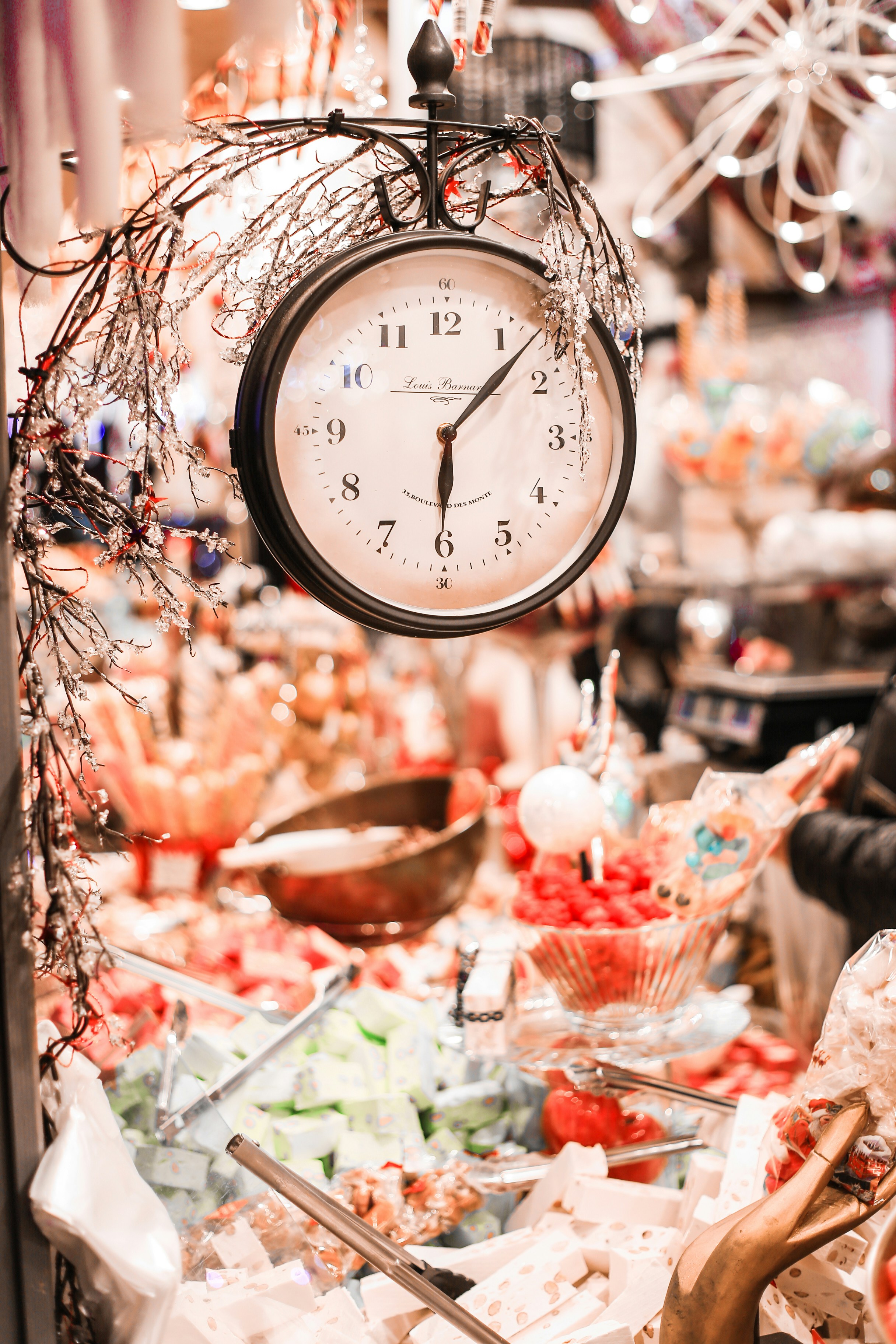 Timekeeper in a Holiday Bazaar: A Clock Amid Candy and Gifts