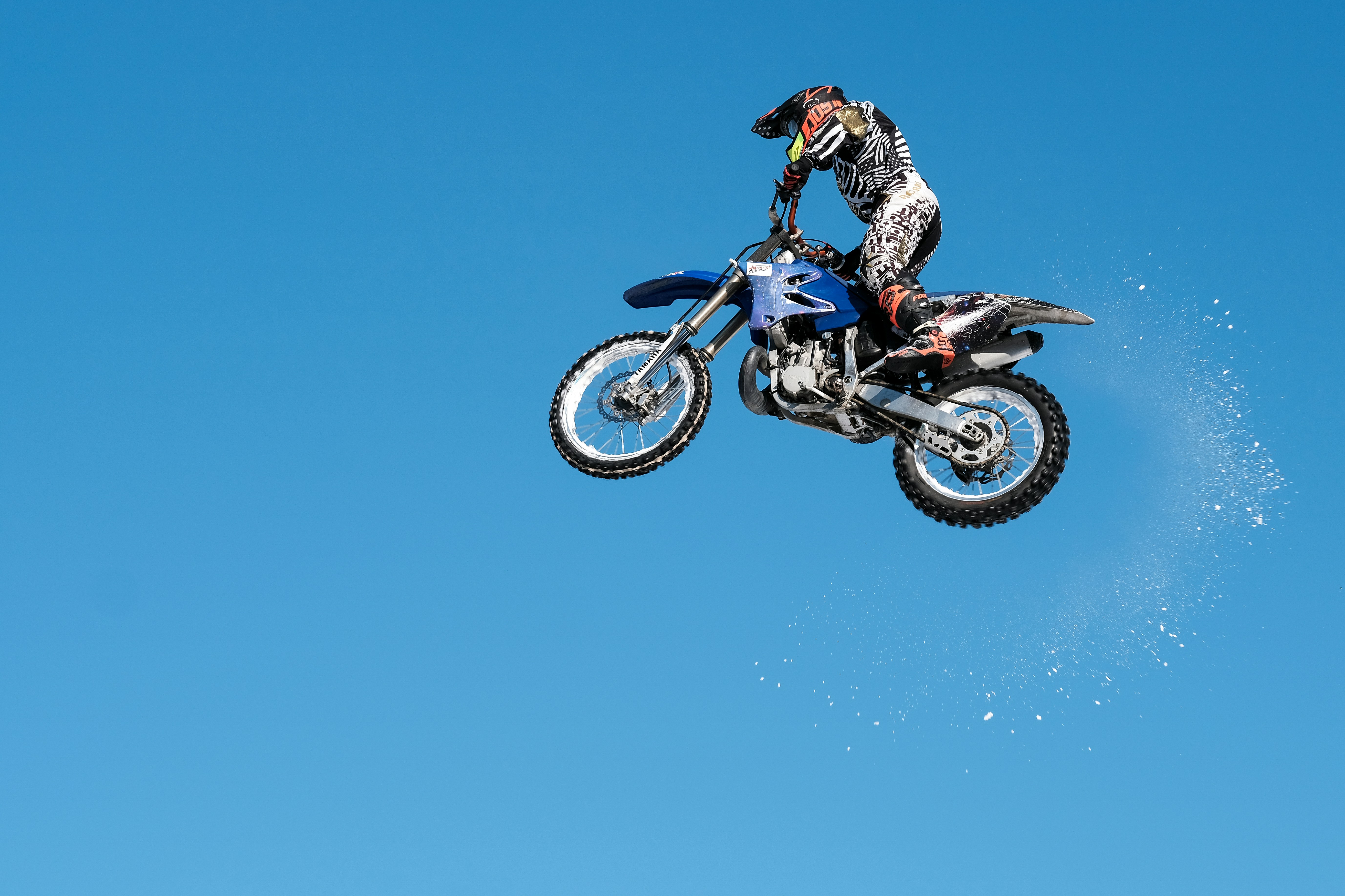 Mid-Air Moto: Rider Casts Shadow on a Clear Blue Sky