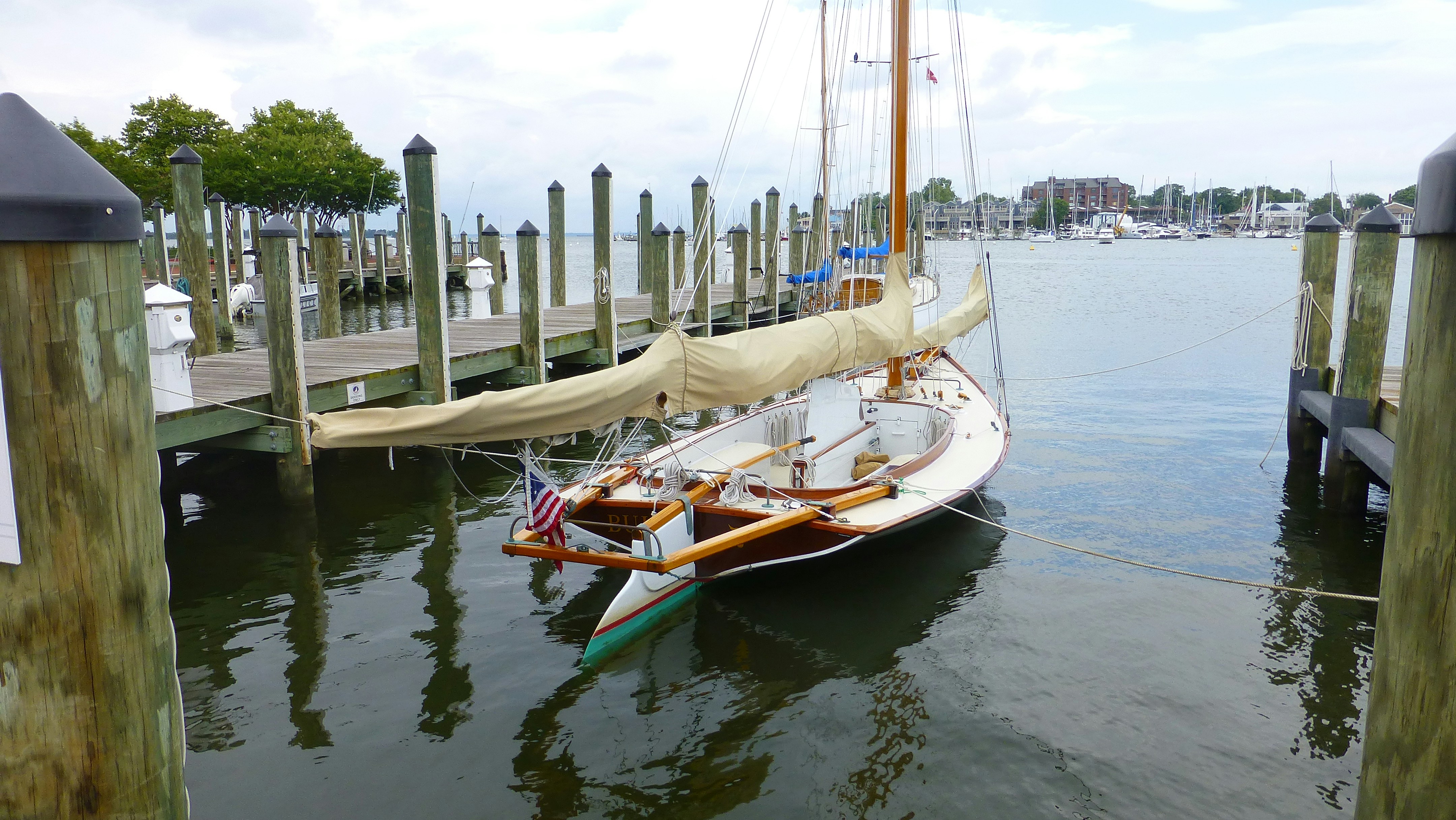Sailboat at the Pier: Calm harbor, weathered wood, and folded canvas