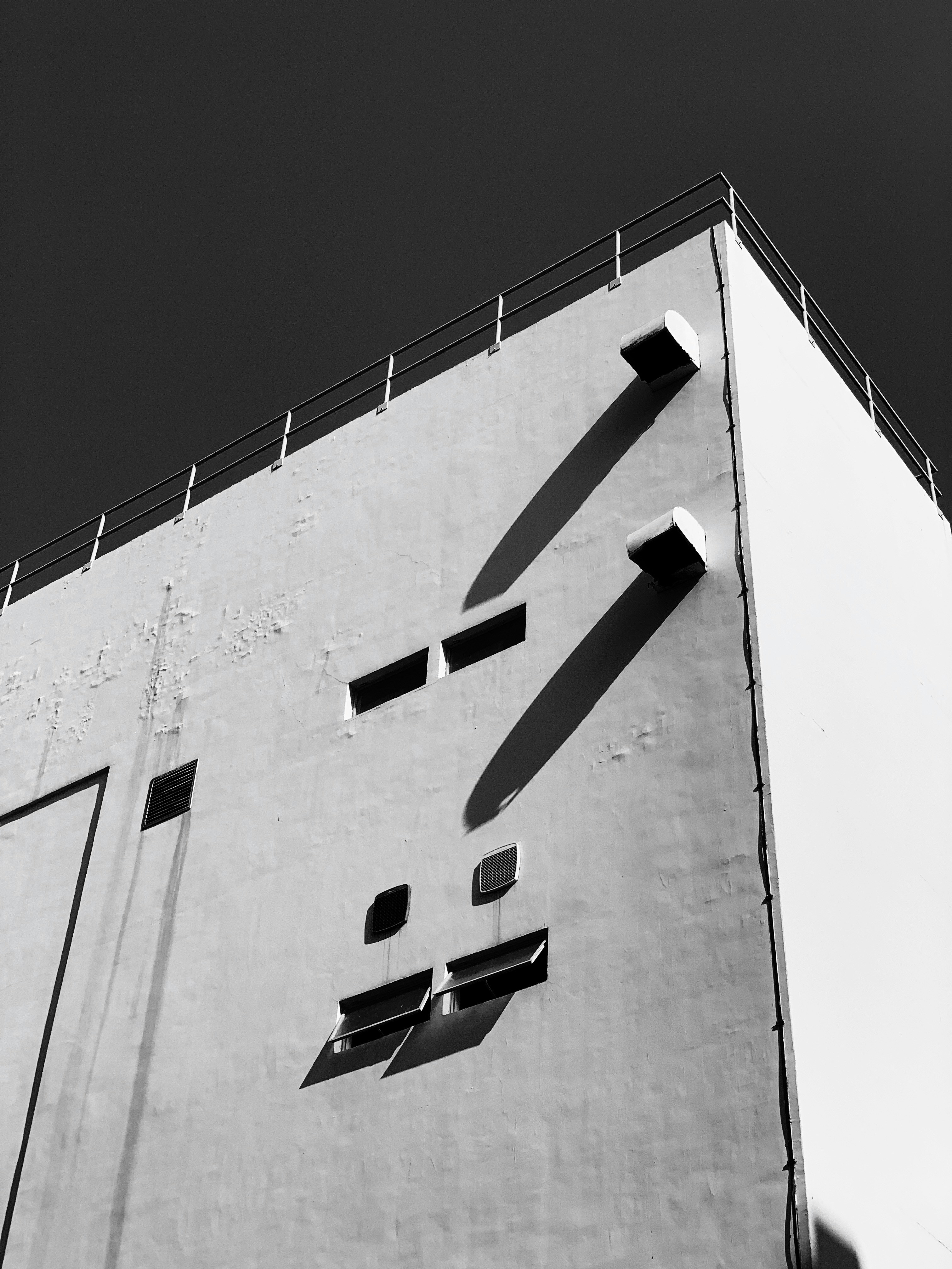 Diagonal Shadows on a Corner Wall: A Monochrome Facade Study