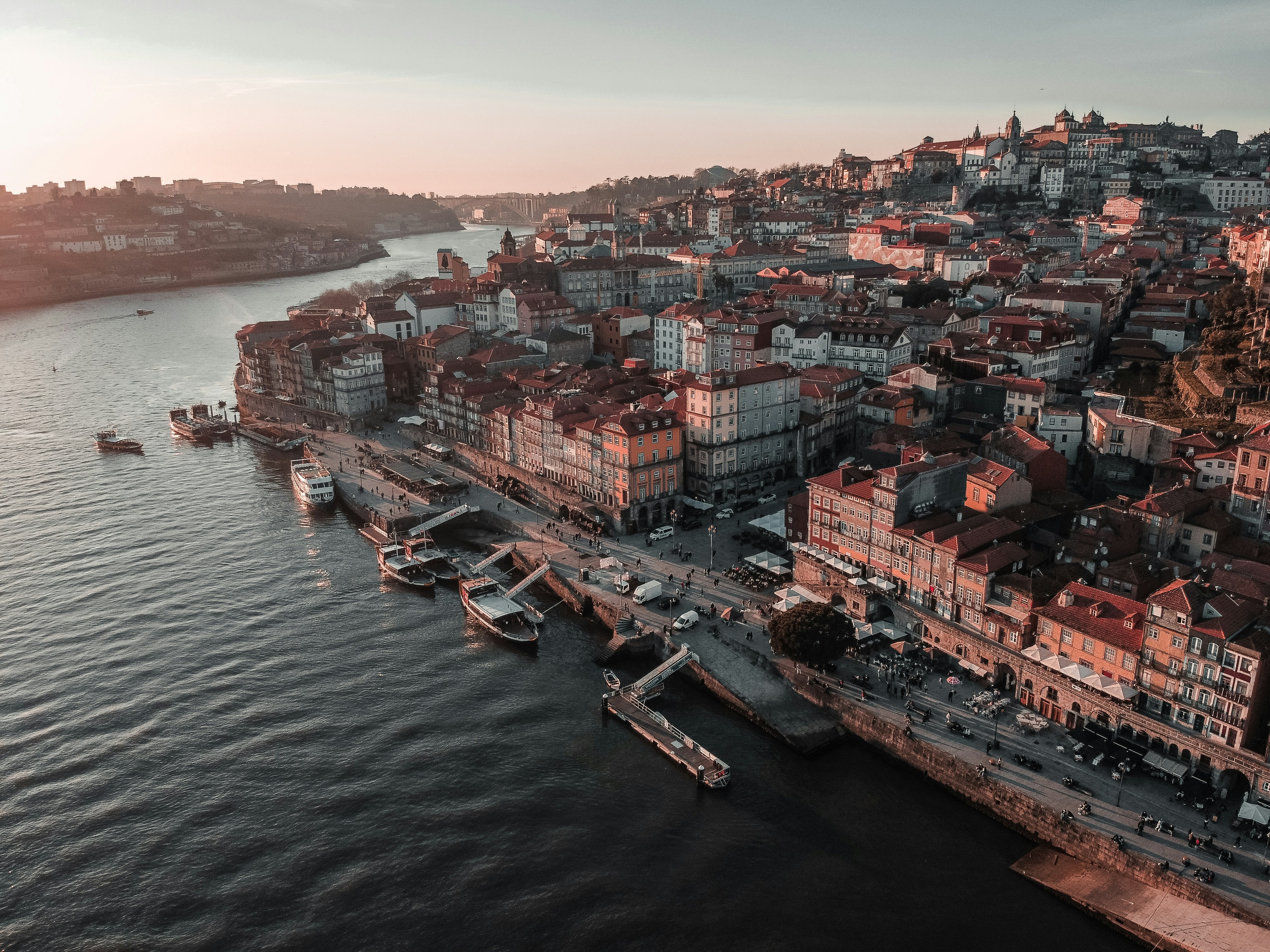Aerial view of a historic riverside cityscape bathed in warm evening light.