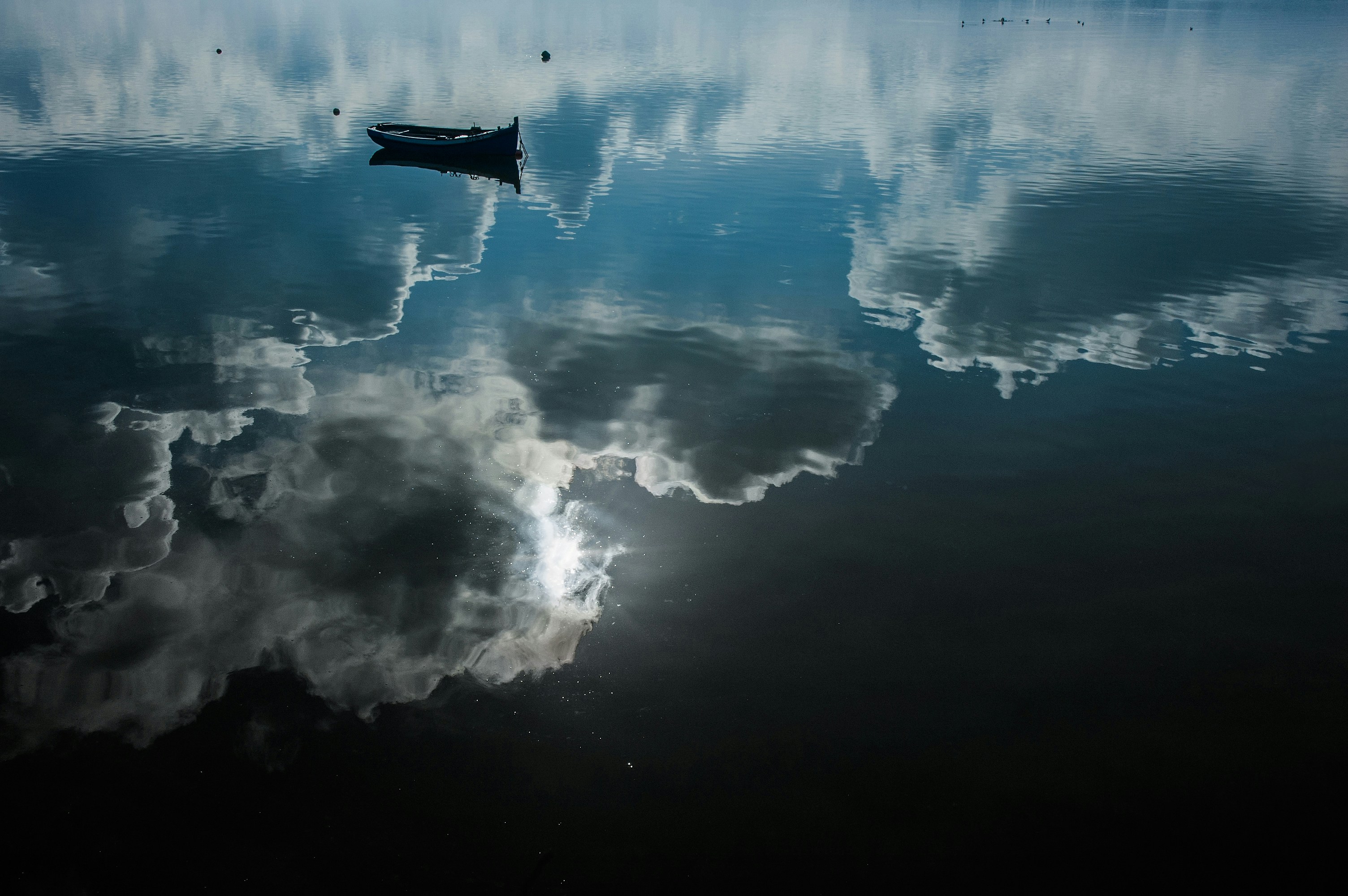Boat Drift in a Sky-Reflective Lake