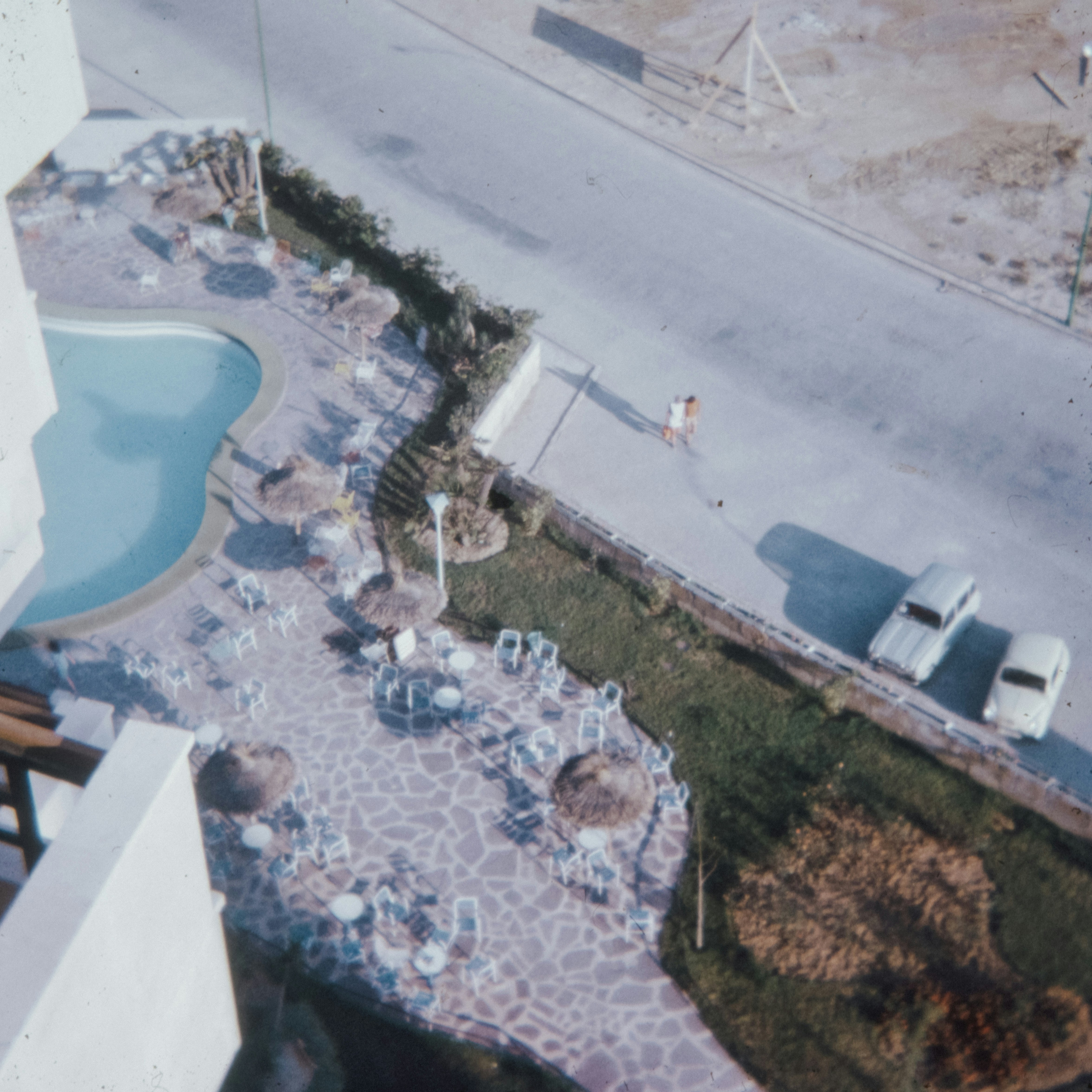 Aerial View of Poolside Oasis Framed by Terrace and Road