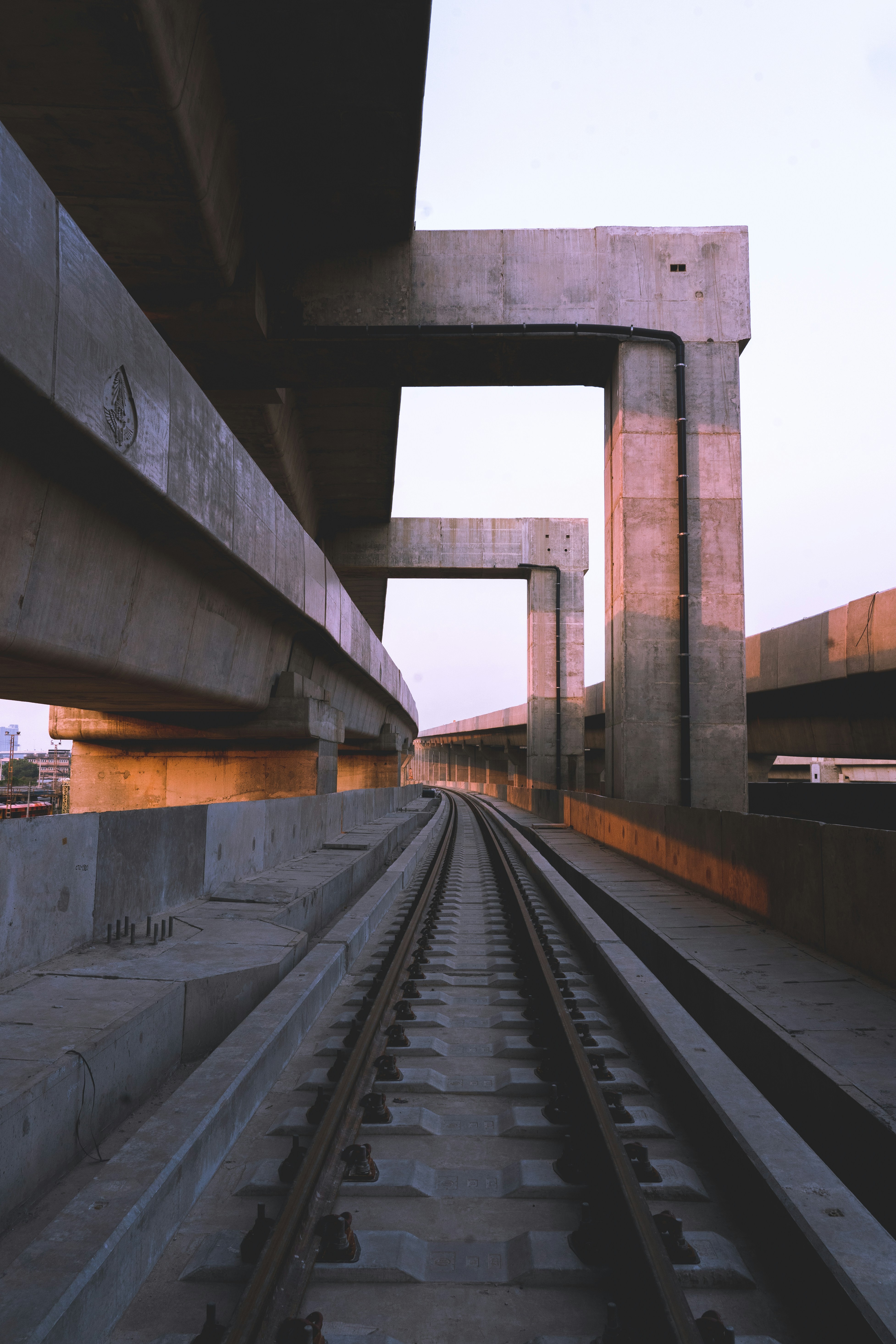 Converging Rails Under Concrete Giants