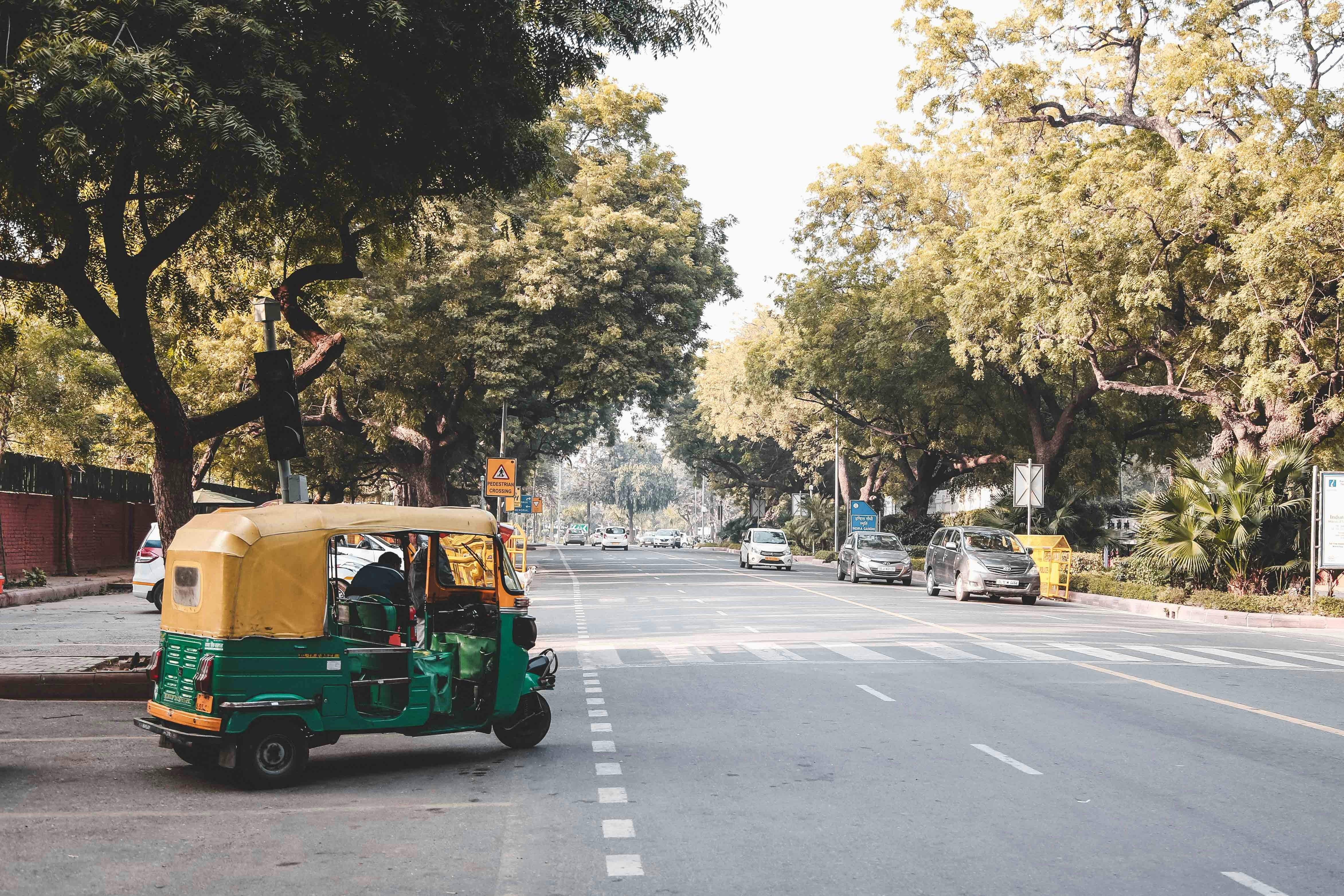 People riding green and yellow auto rickshaw on road during daytime ...