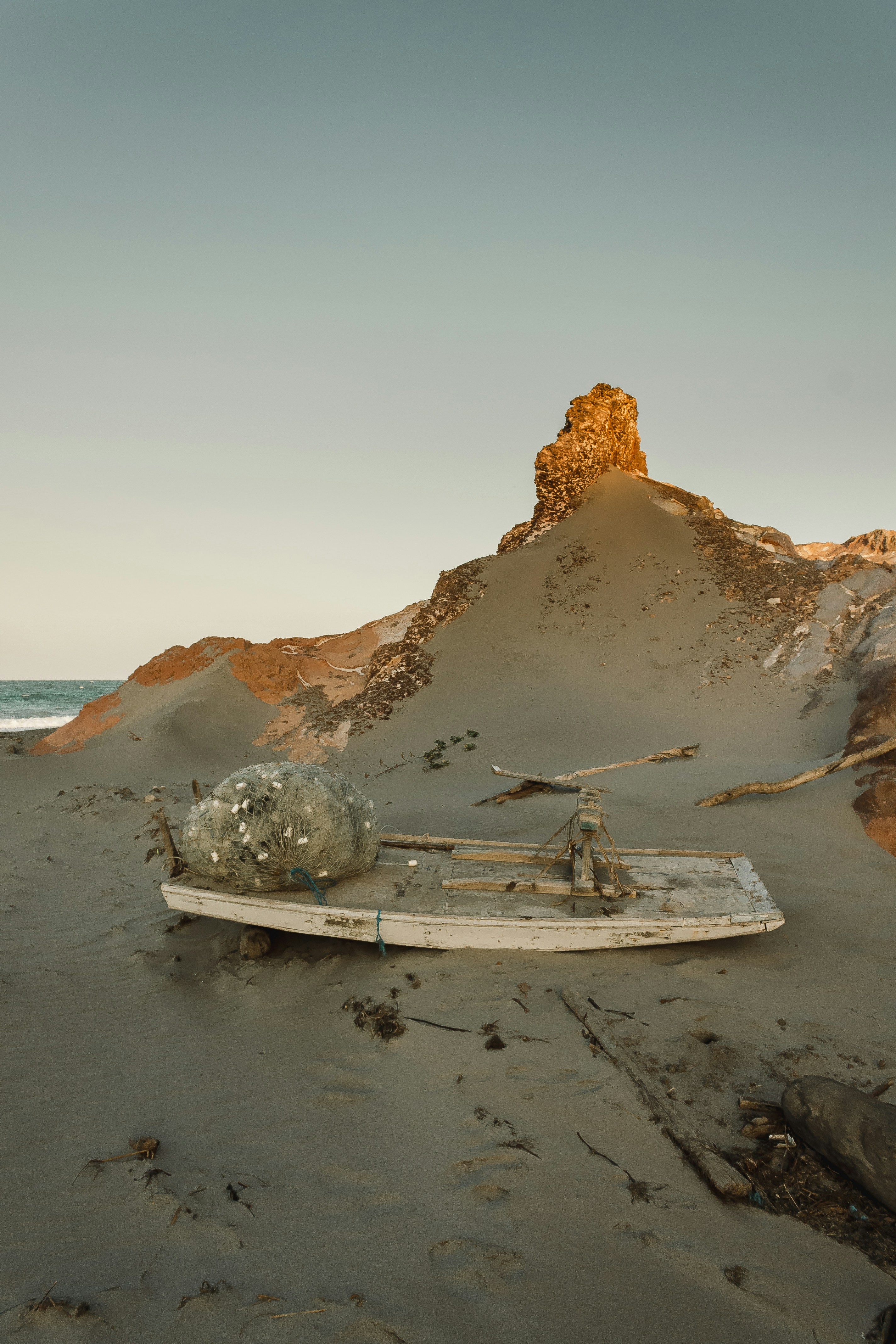 Brown wooden boat on seashore near brown rock formation during daytime ...
