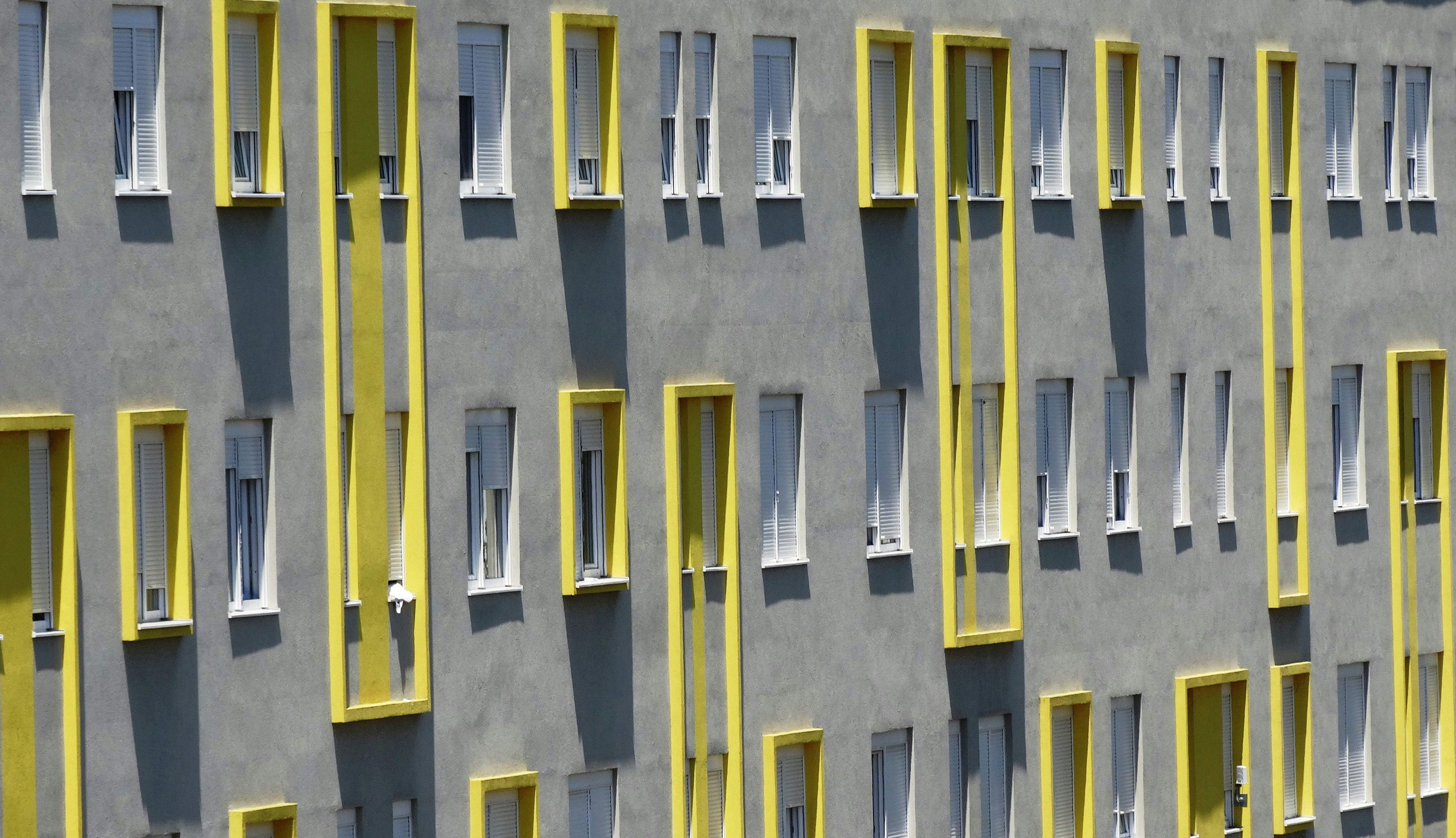 Urban Geometry: Yellow-Framed Windows on a Gray Facade