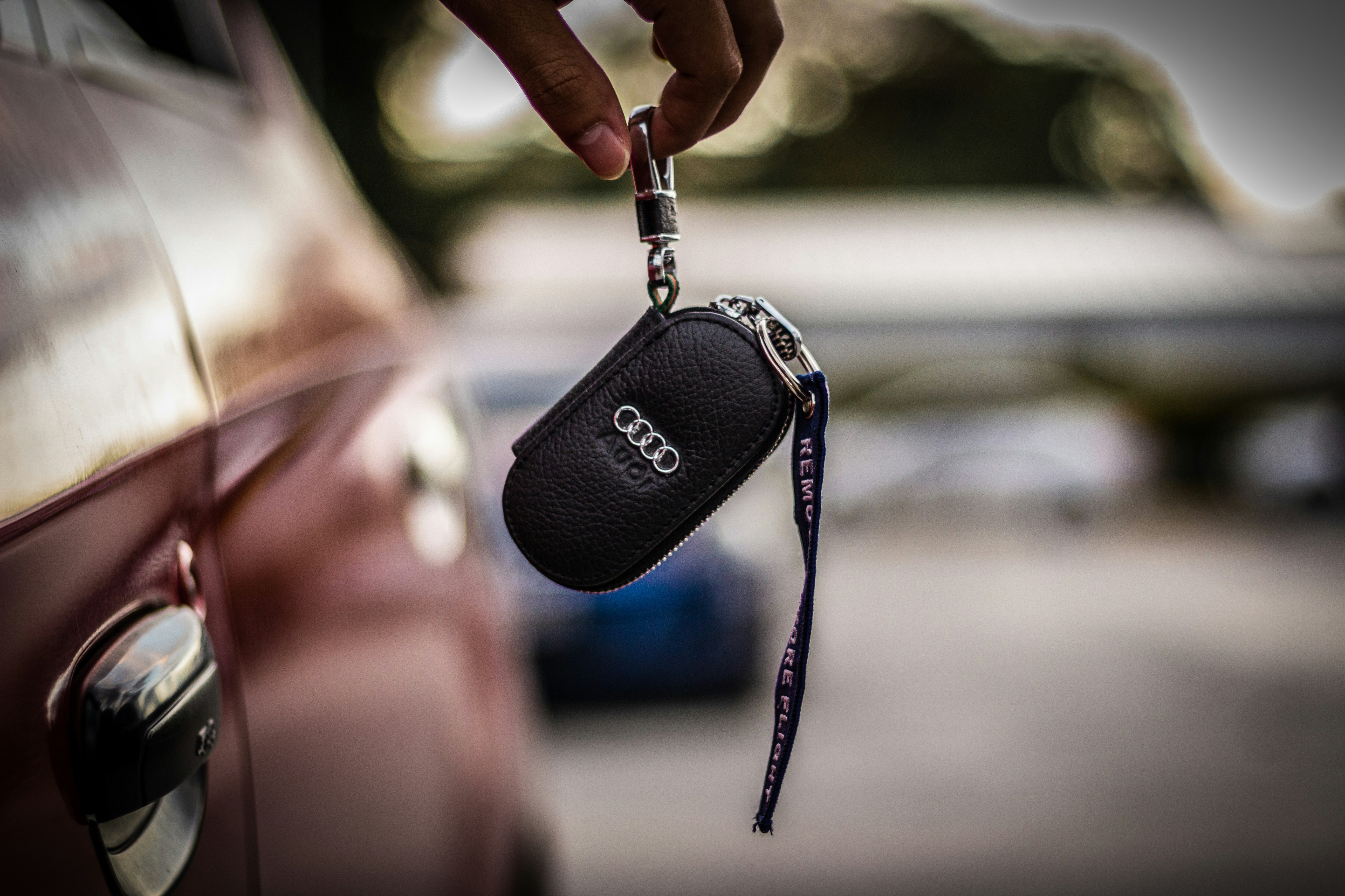 Keyed Confidence: A Focus on the Audi Key Against a Blurred Vehicle Backdrop