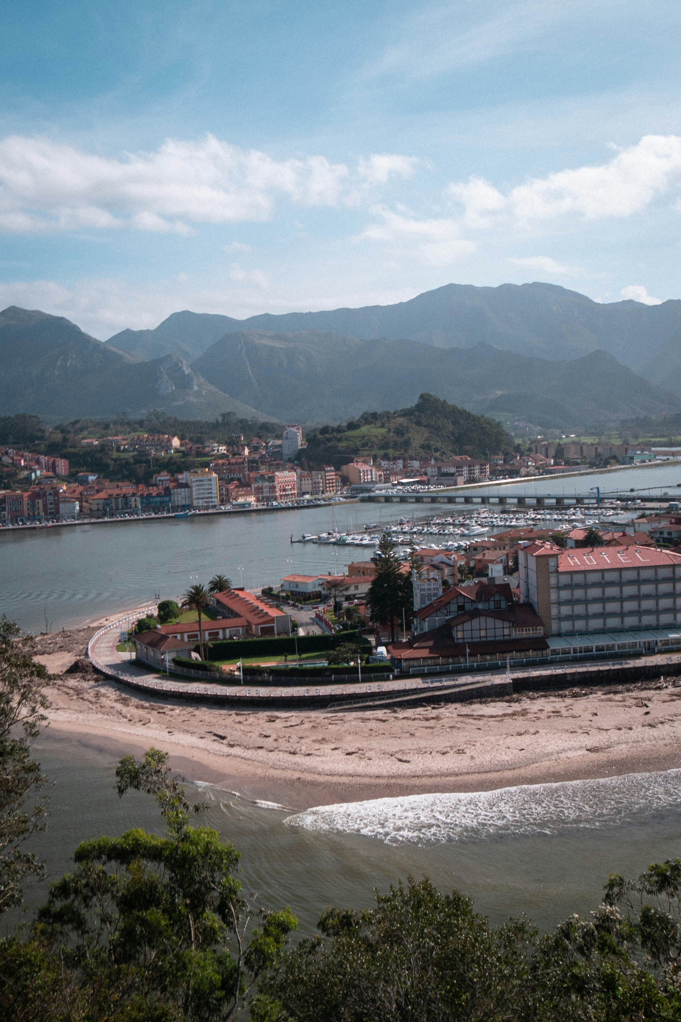 Harbor Promenade and Red Roofs: Coastal Town Framed by Distant Peaks