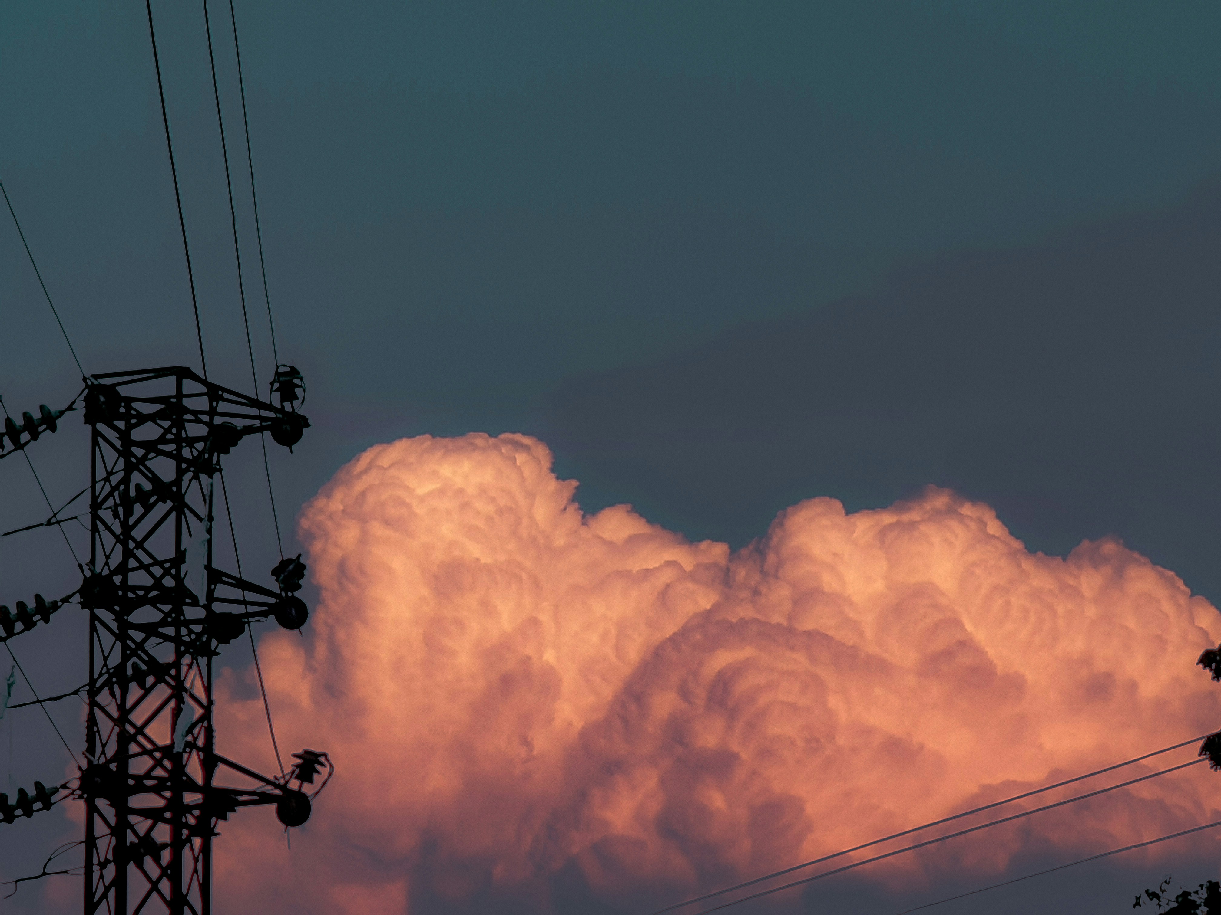 Dusk Cloudscape Framed by a Lattice of Transmission Towers