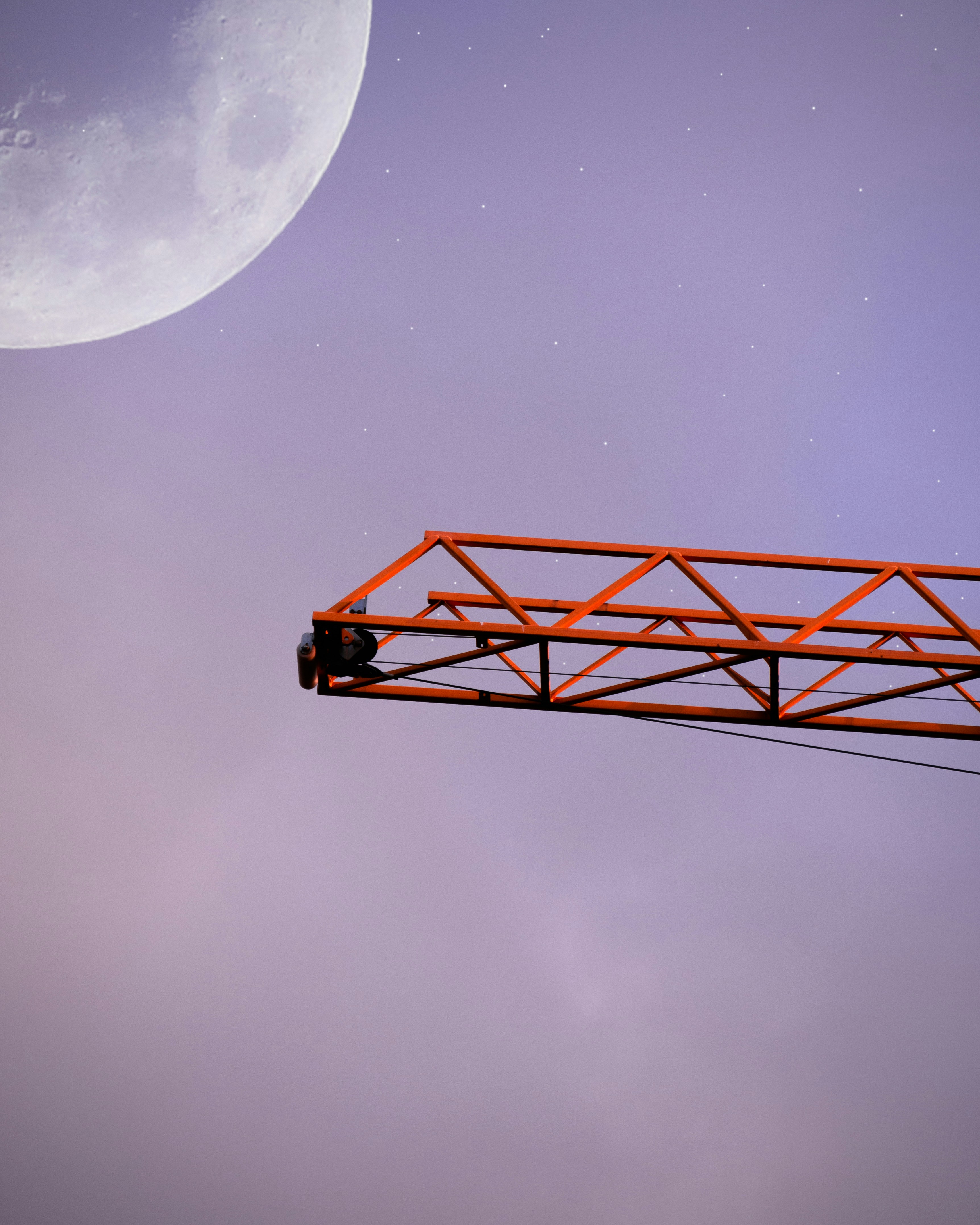 Moonlit Crane: A Red Truss Against Evening Twilight