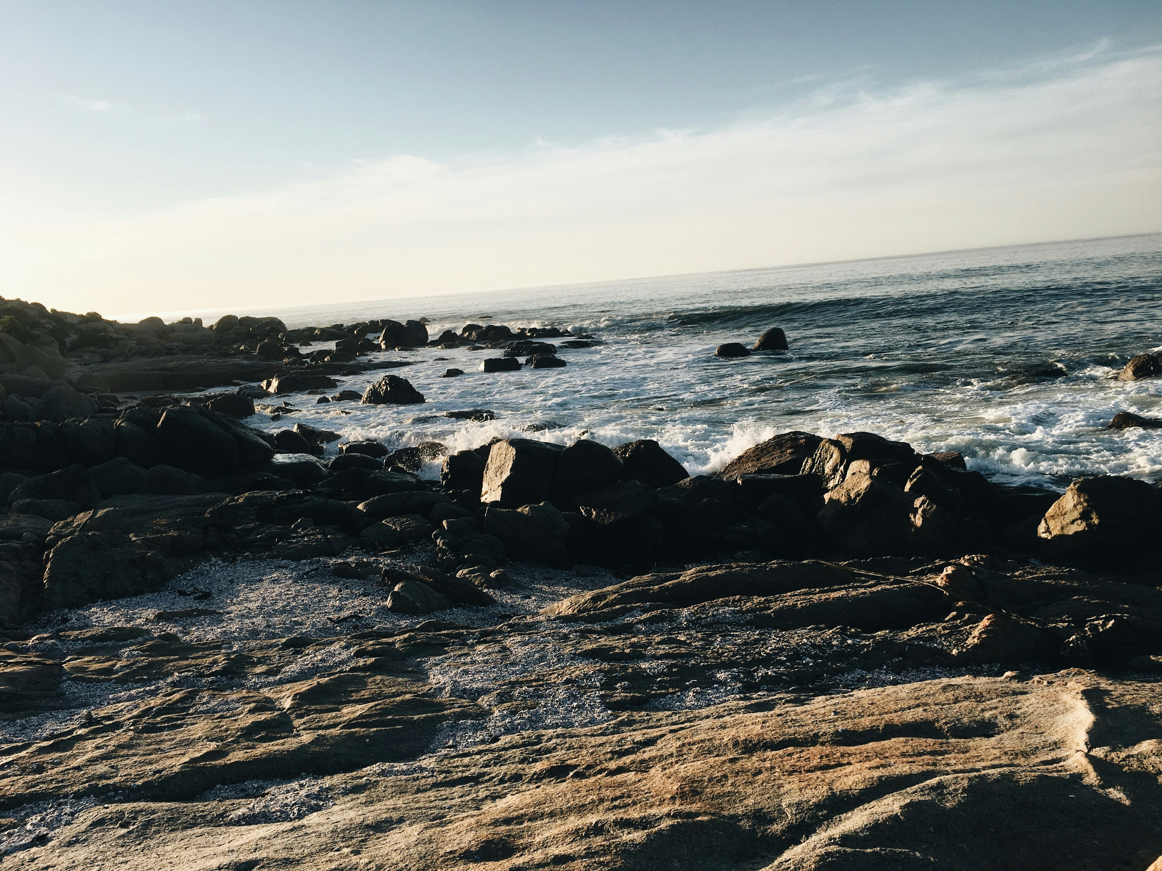 Black rocks on sea shore during daytime photo – Free South africa Image ...
