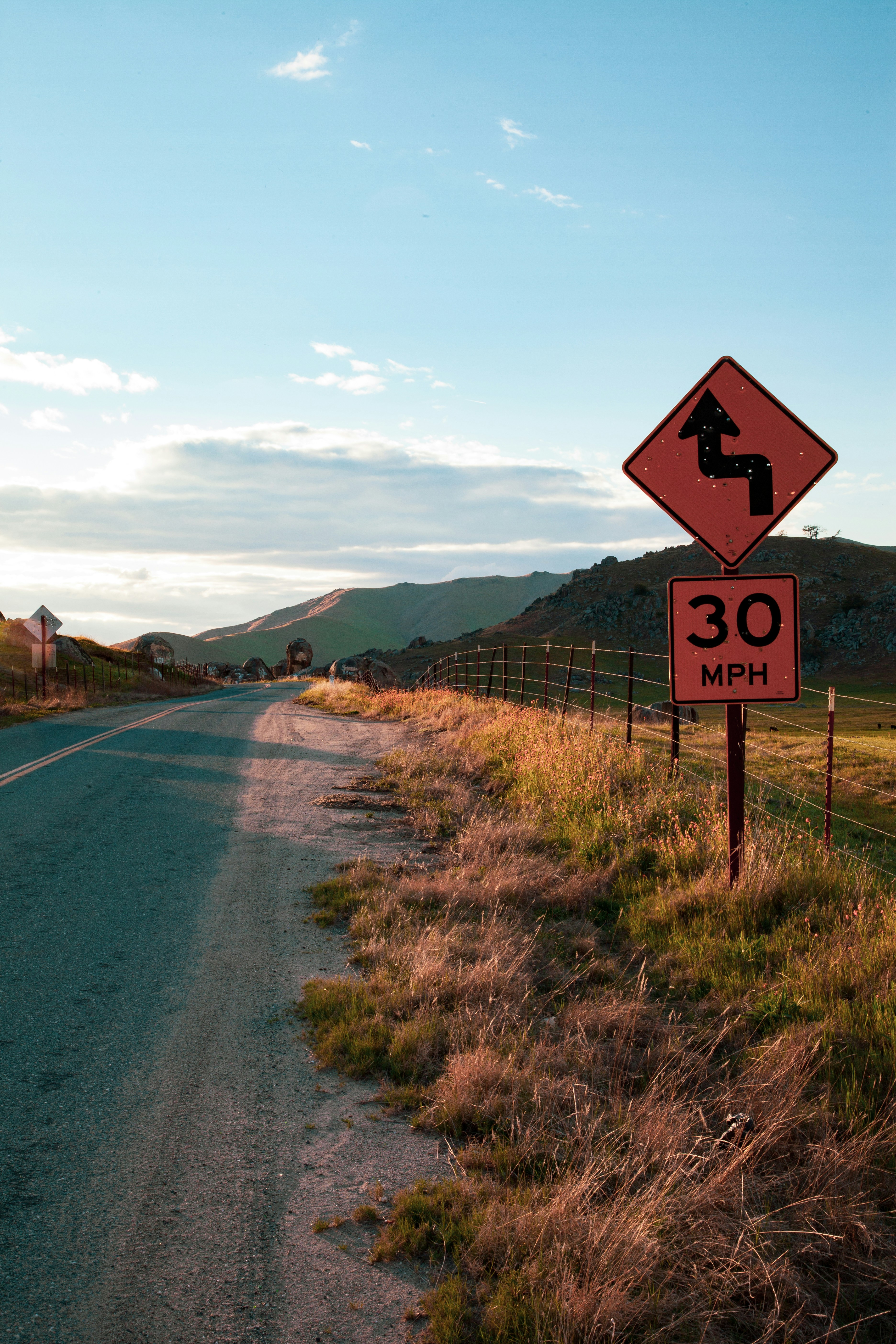 Road Sign at the Bend: Sunset Cue on a Quiet Highway