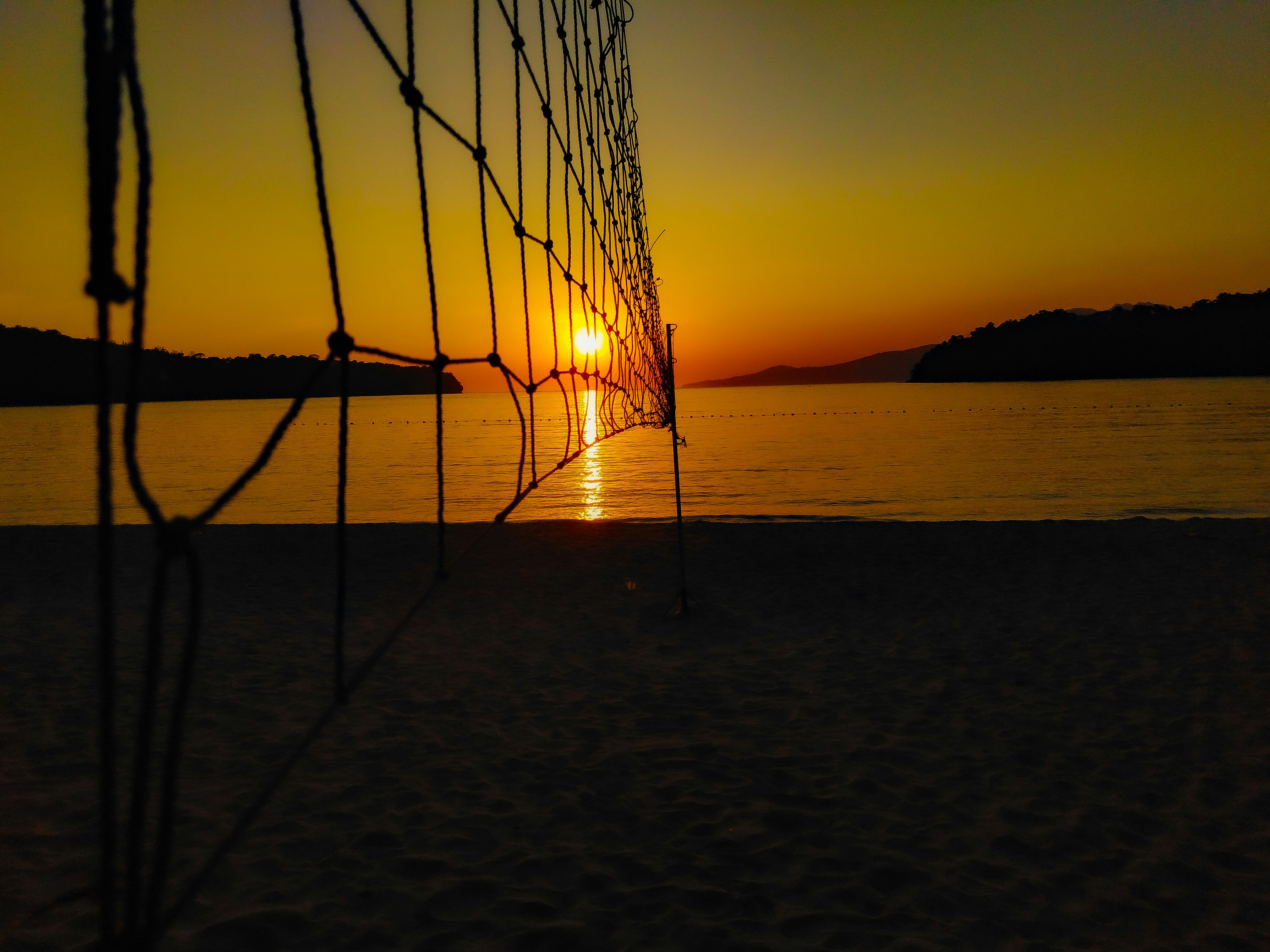 Sunset Volley: Mesh of Net and Dusk Over Quiet Shore