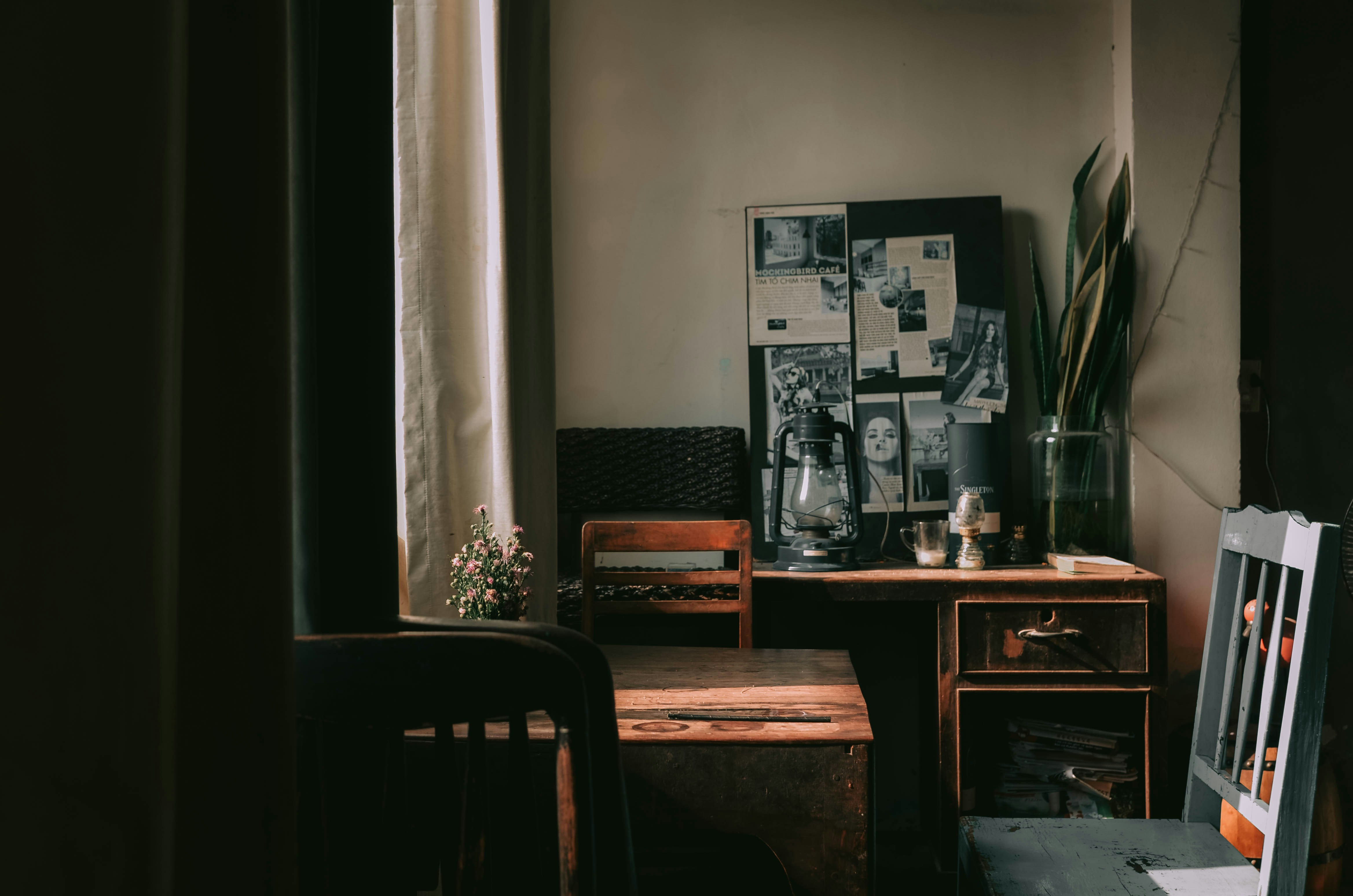 brown wooden table near white window curtain