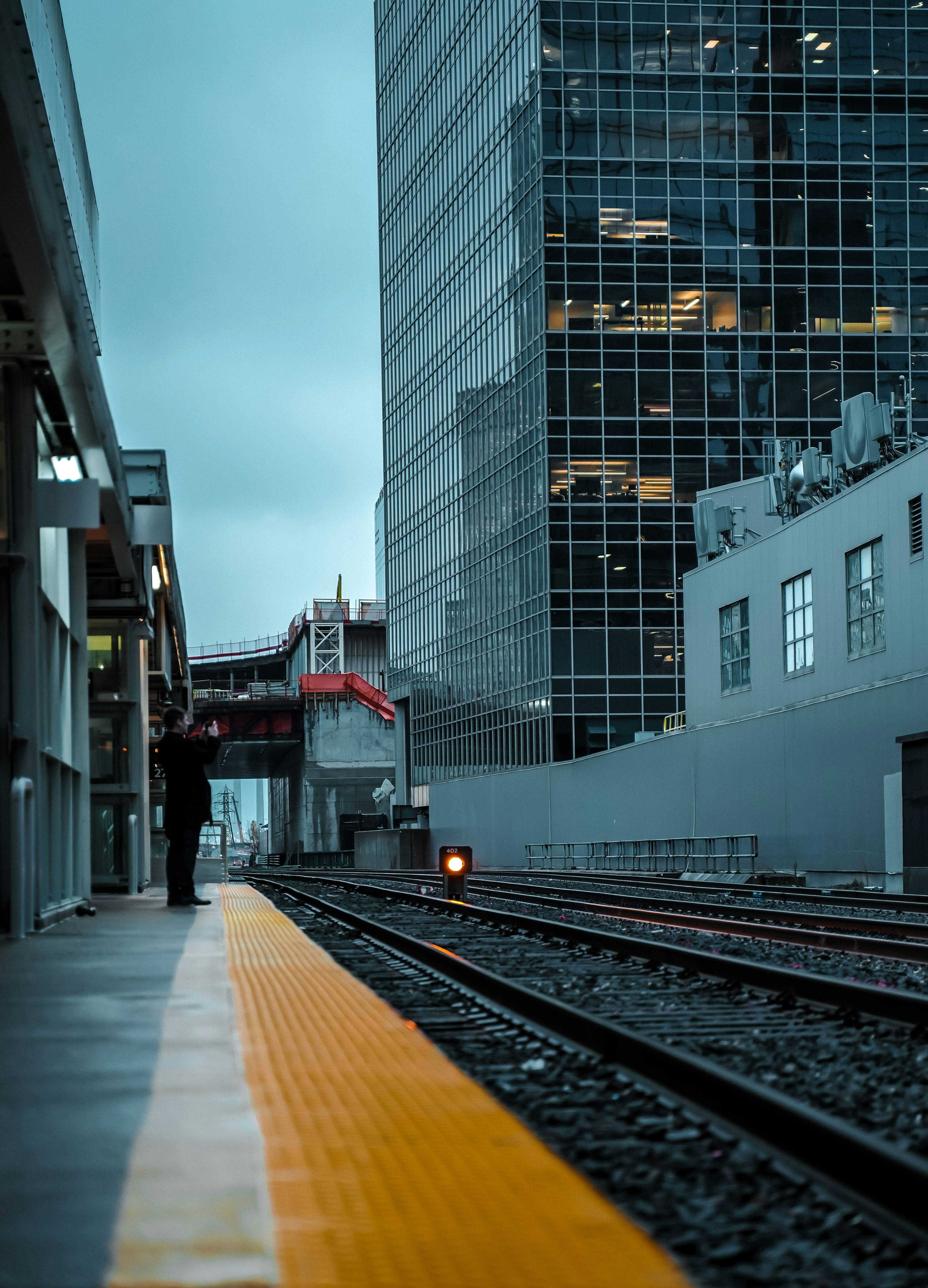 Red and white train on rail road between buildings during daytime photo ...