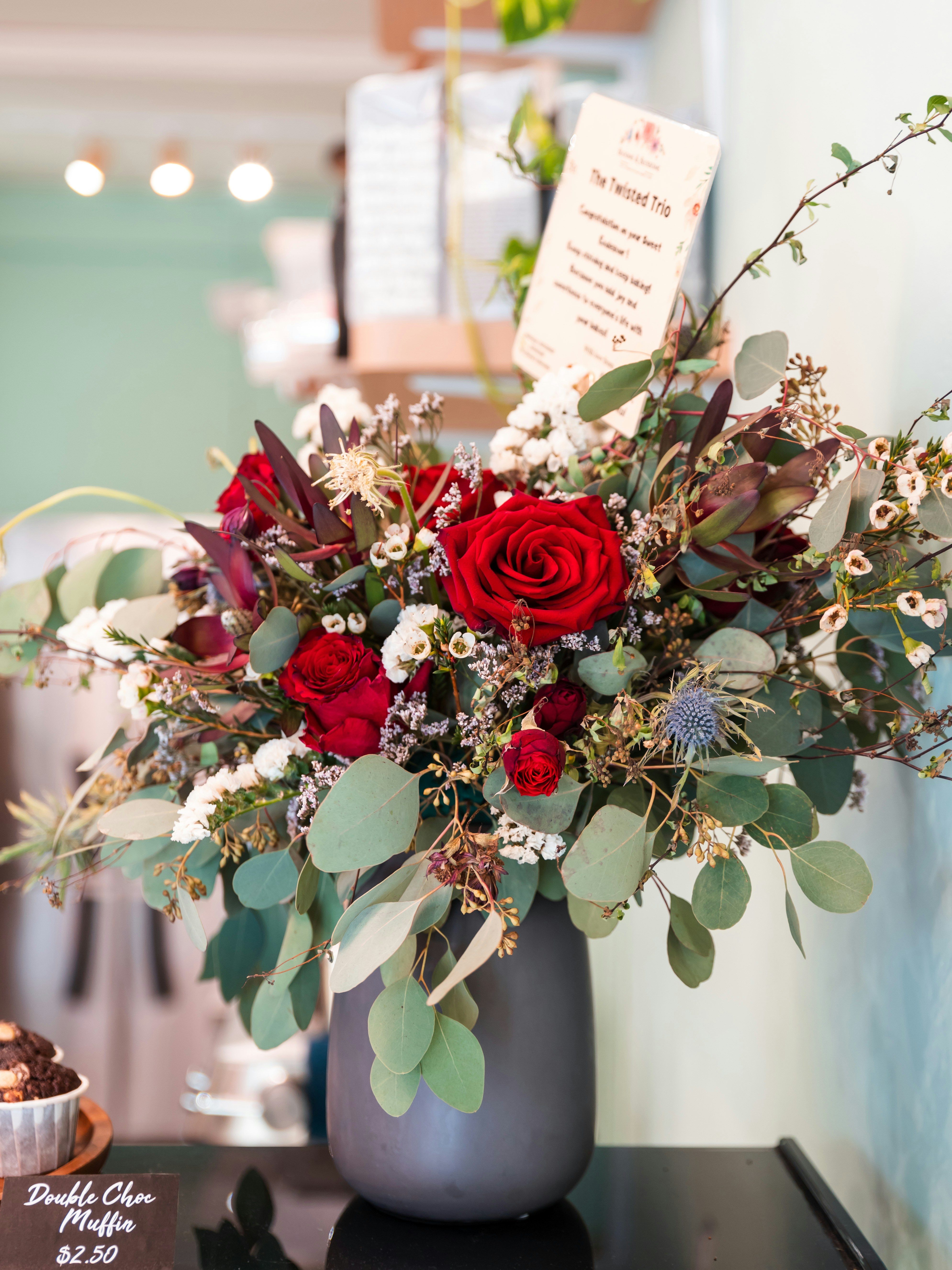 Red Roses in a Rustic Floral Arrangement at a Softly Lit Display