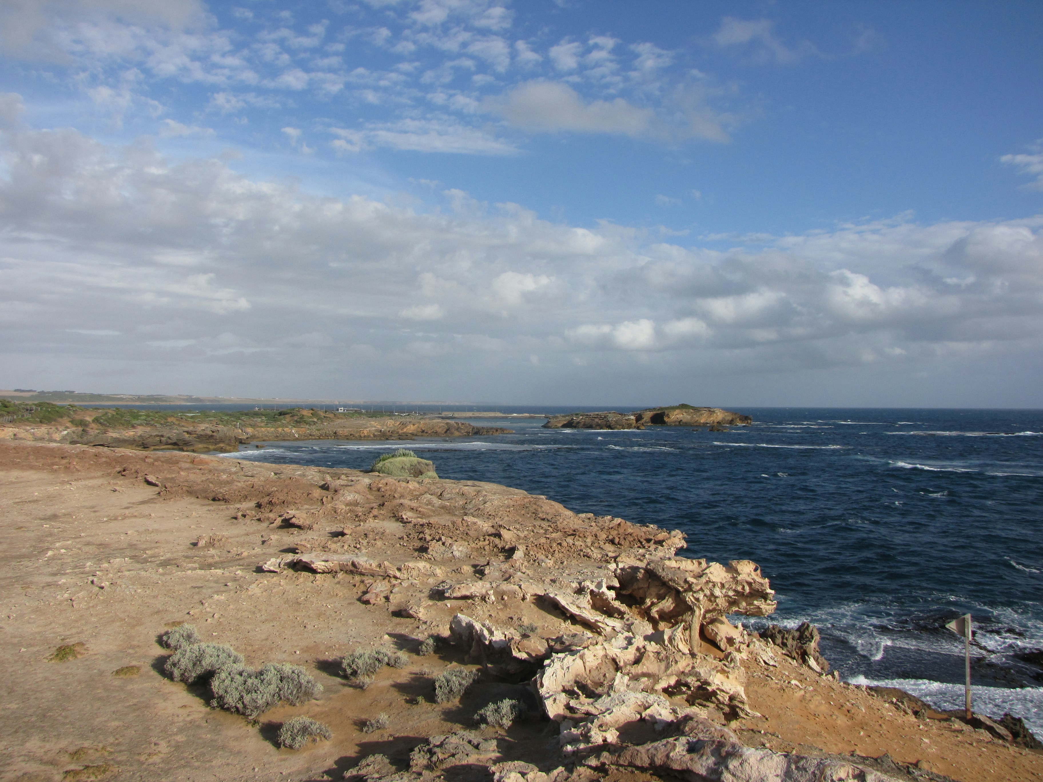 Rocky coastline meeting the ocean under a dynamic sky, showcasing the rugged beauty of nature.