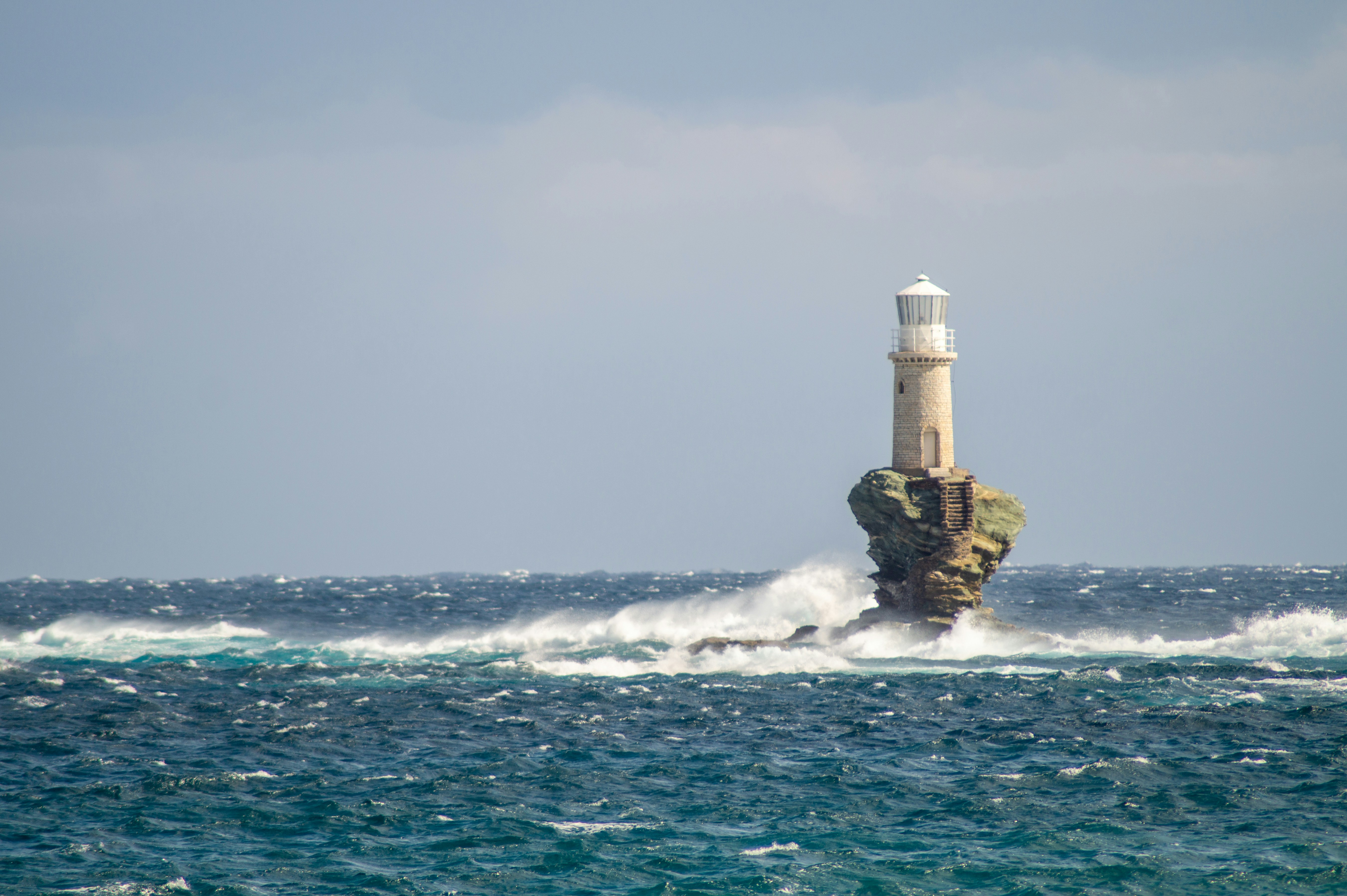 White and brown lighthouse on ocean water during daytime photo – Free ...