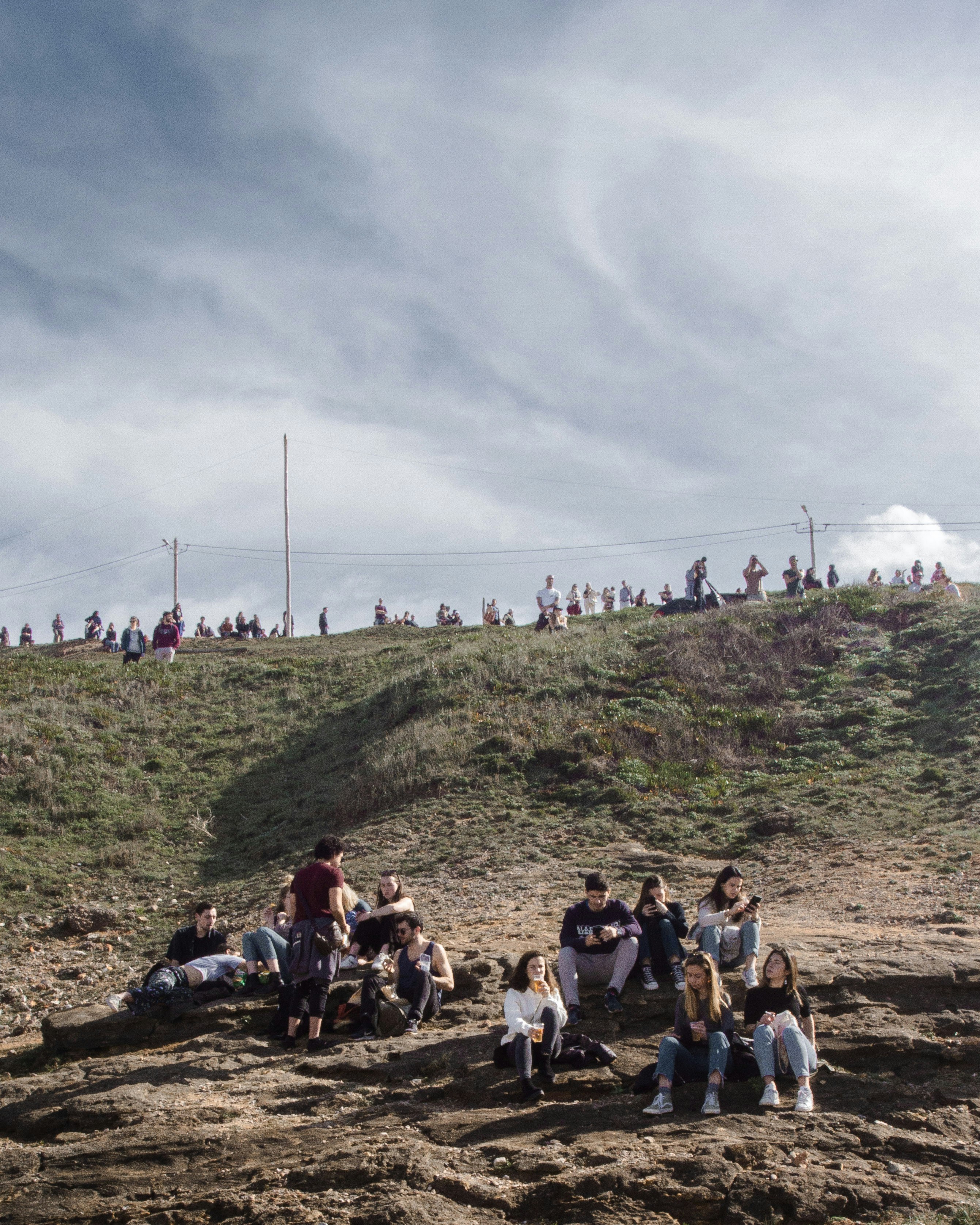 Horizon Assembly: A sunlit hillside crowd gathers along a ridge beneath a vast sky