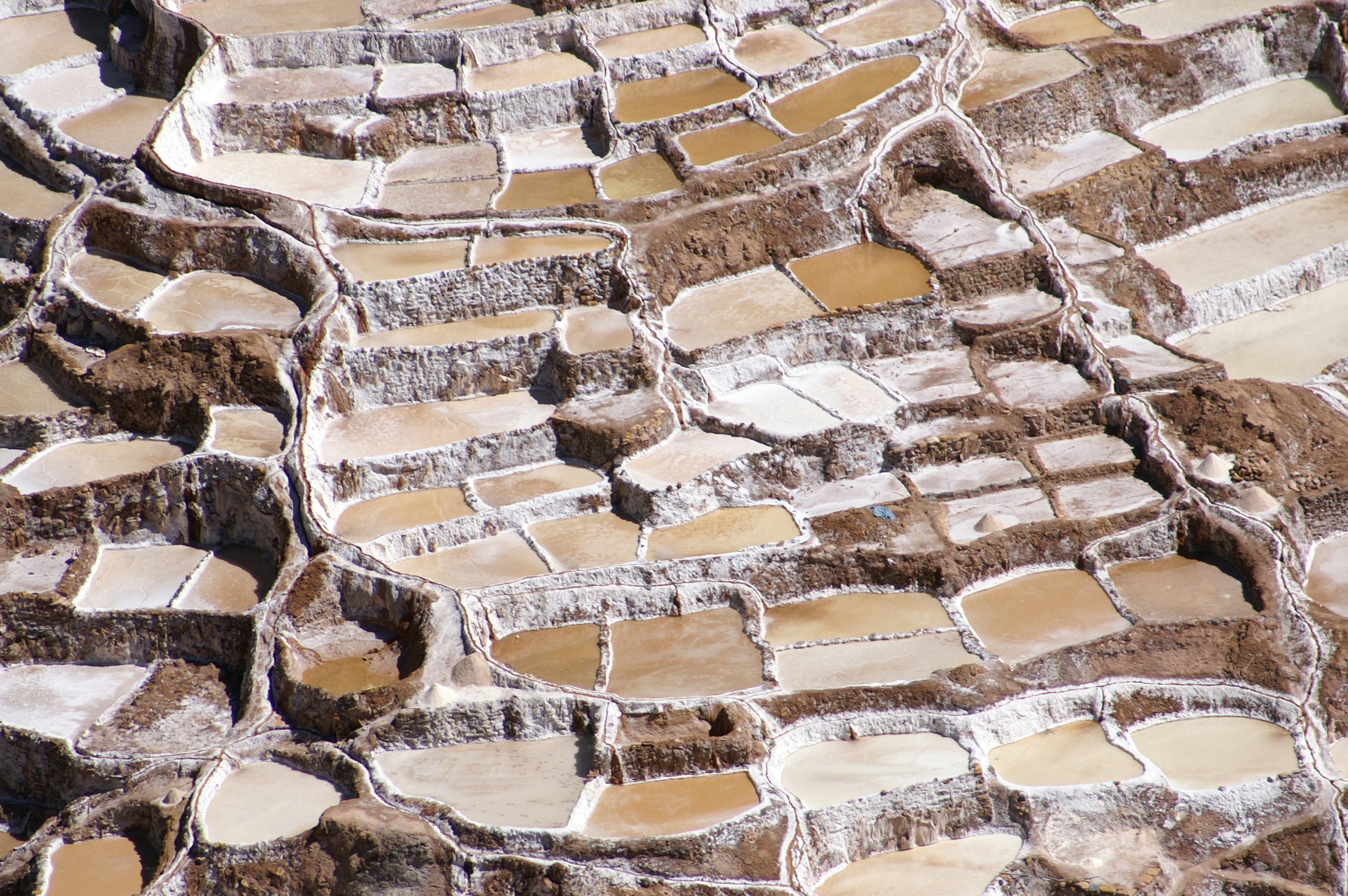 Intricate network of salt pans showcasing a mosaic of natural patterns and textures. This aerial view highlights the artistry of traditional salt harvesting.