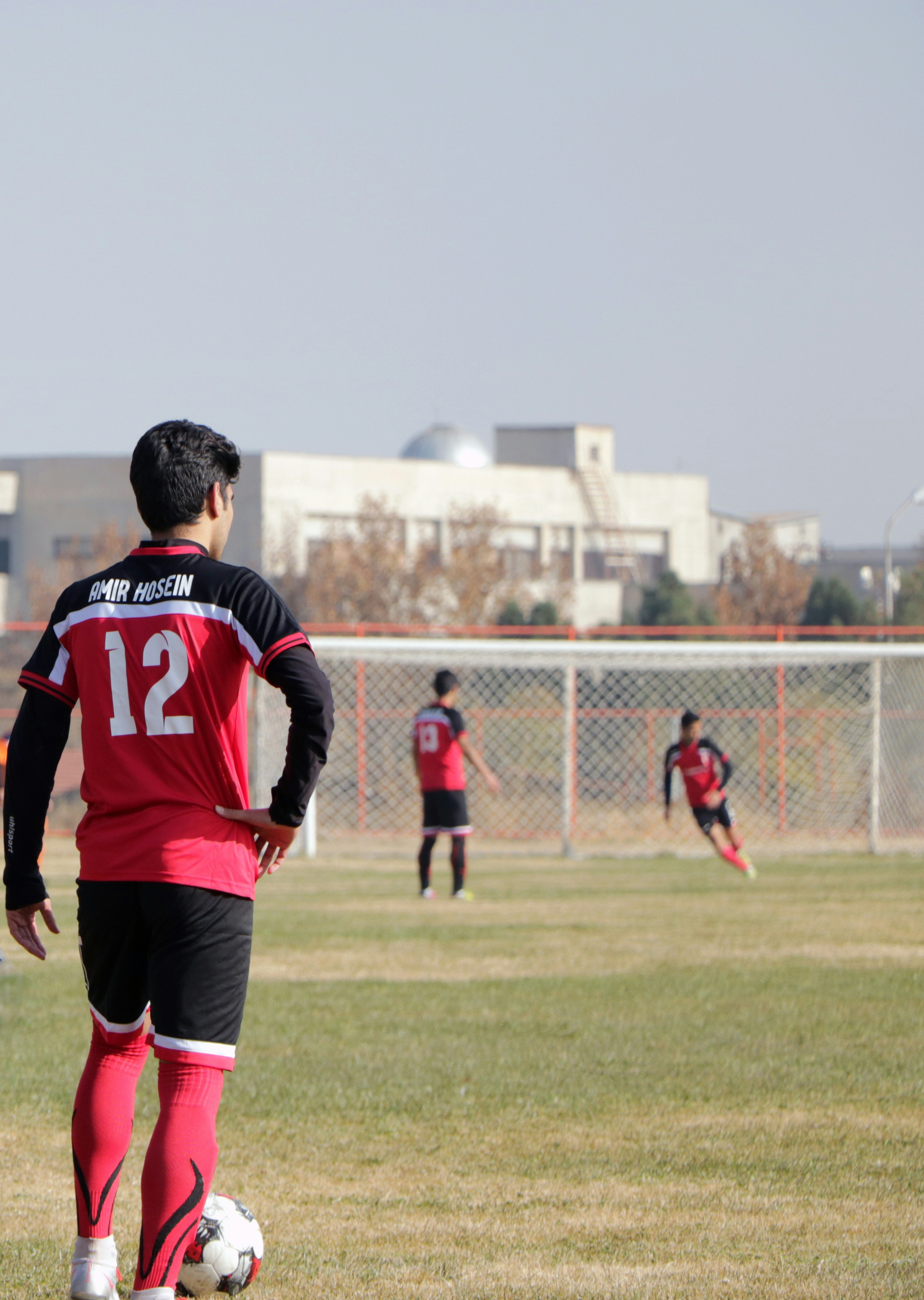 Red-Jersey Captain Oversees a Sunlit Soccer Session