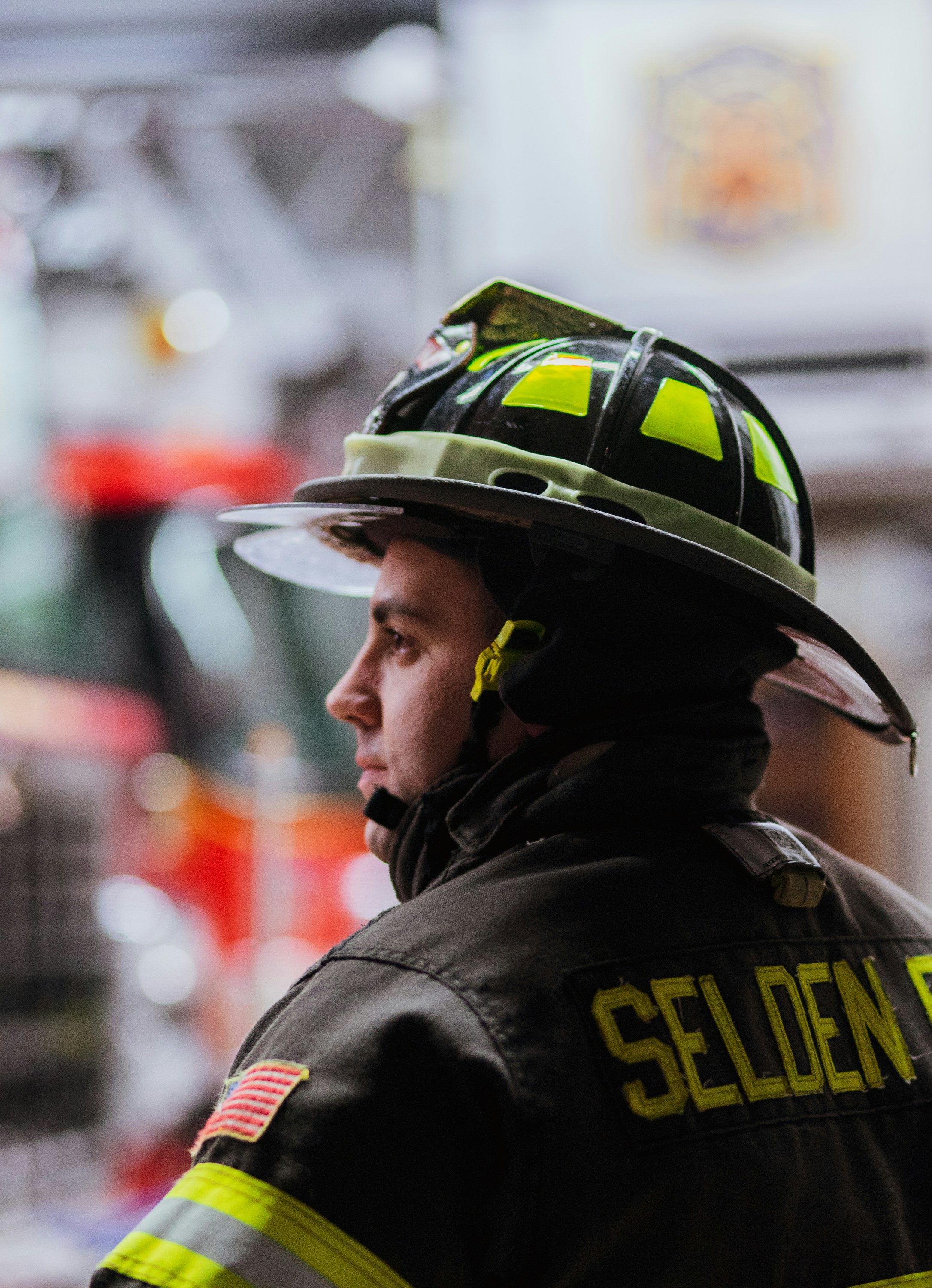 Helmeted Firefighter in Focus, City Morning Behind