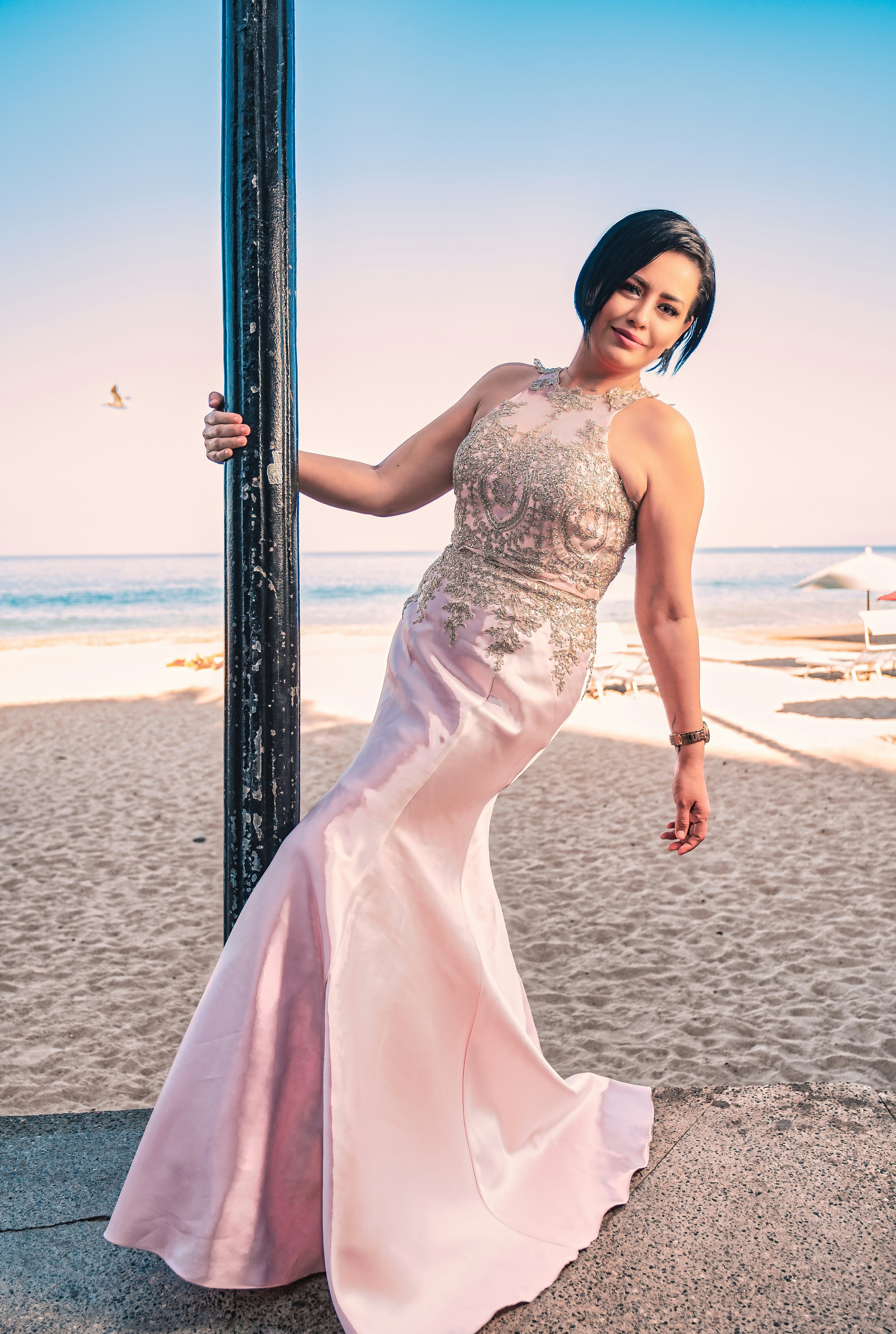 Gilded Silk at Sunset: A seaside portrait leaning into a weathered pole