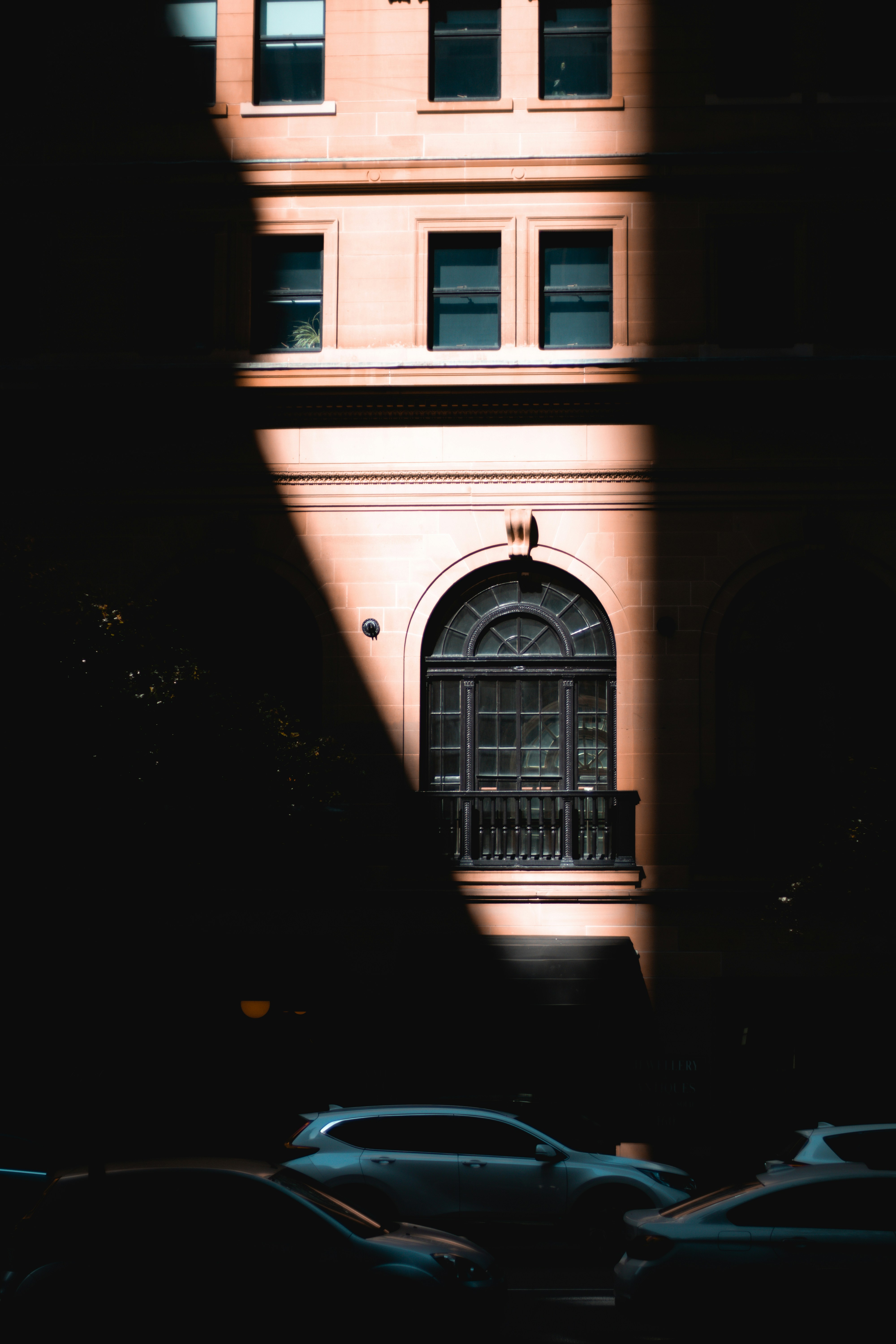 Light Slices Through Stone: Archway in a Shadowed Street