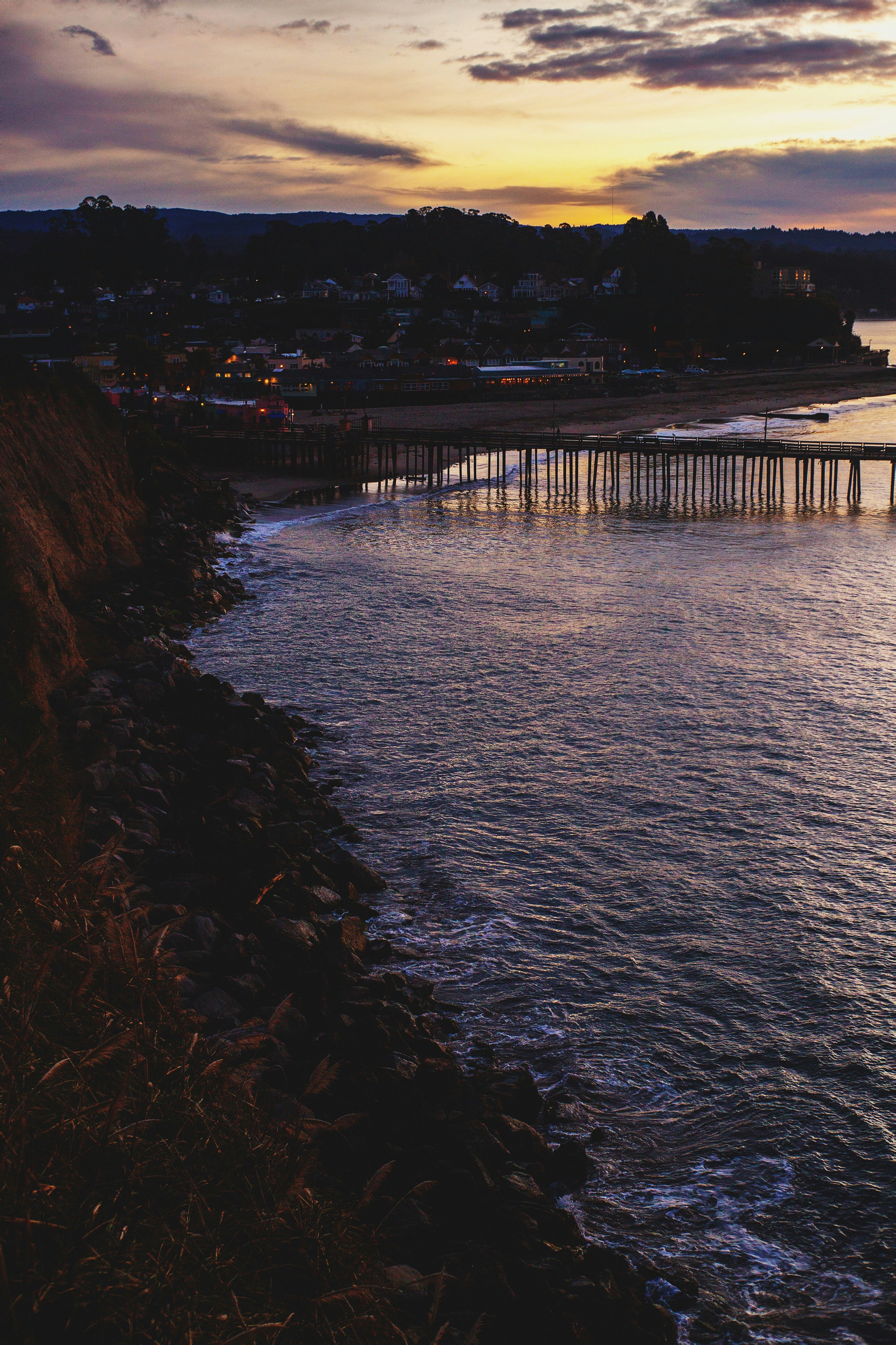 Twilight Pier: Timber Beams, Quiet Coast, and Sunset Reflections