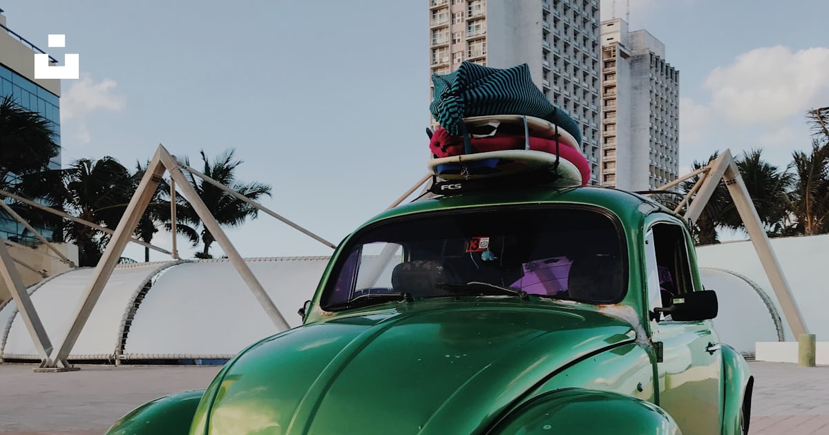 Green Volkswagen Beetle Parked On Brown Brick Floor During Daytime