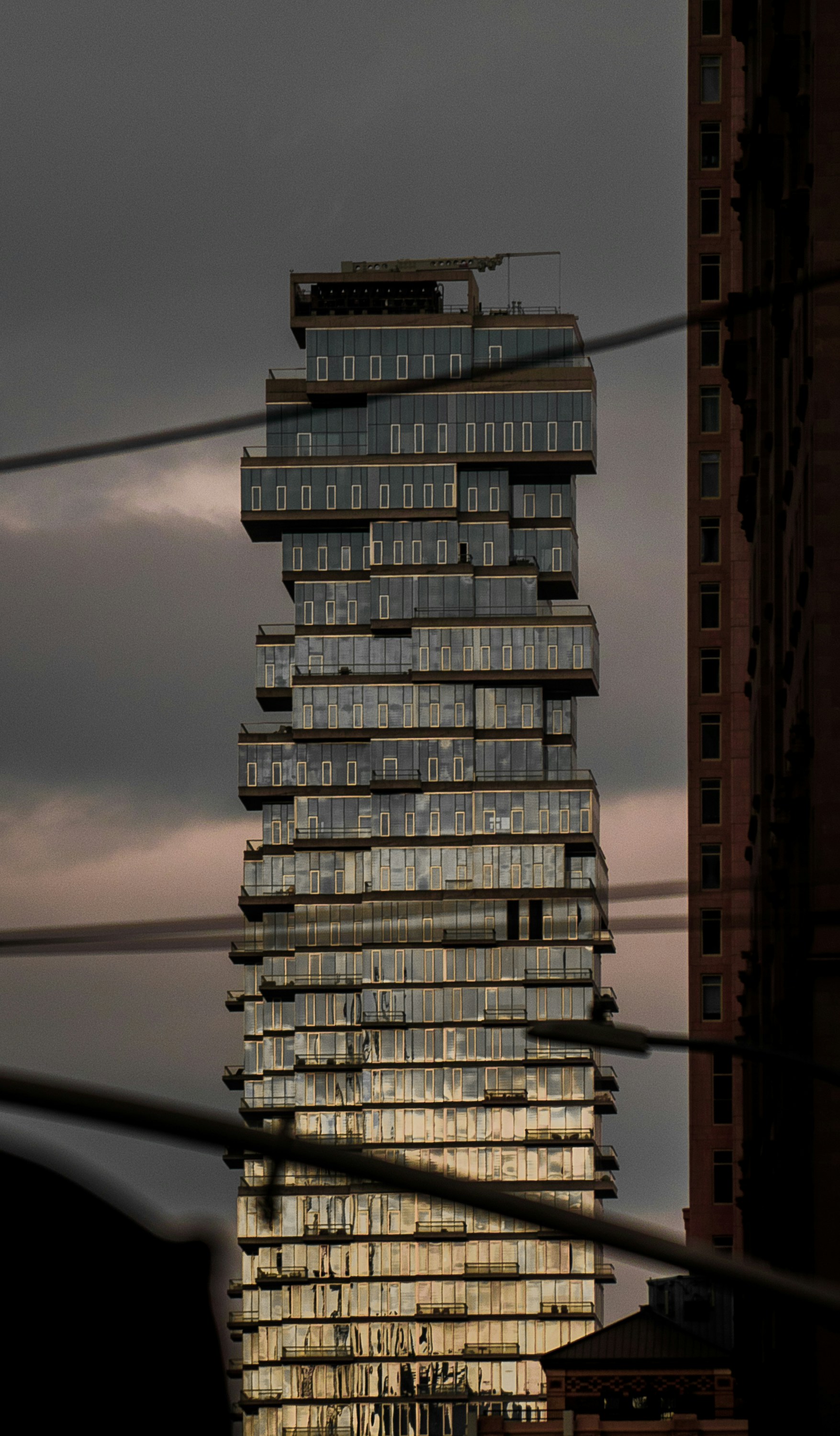 Stacked Echoes: An Asymmetric High-Rloor Tower Reaching the Gray Sky