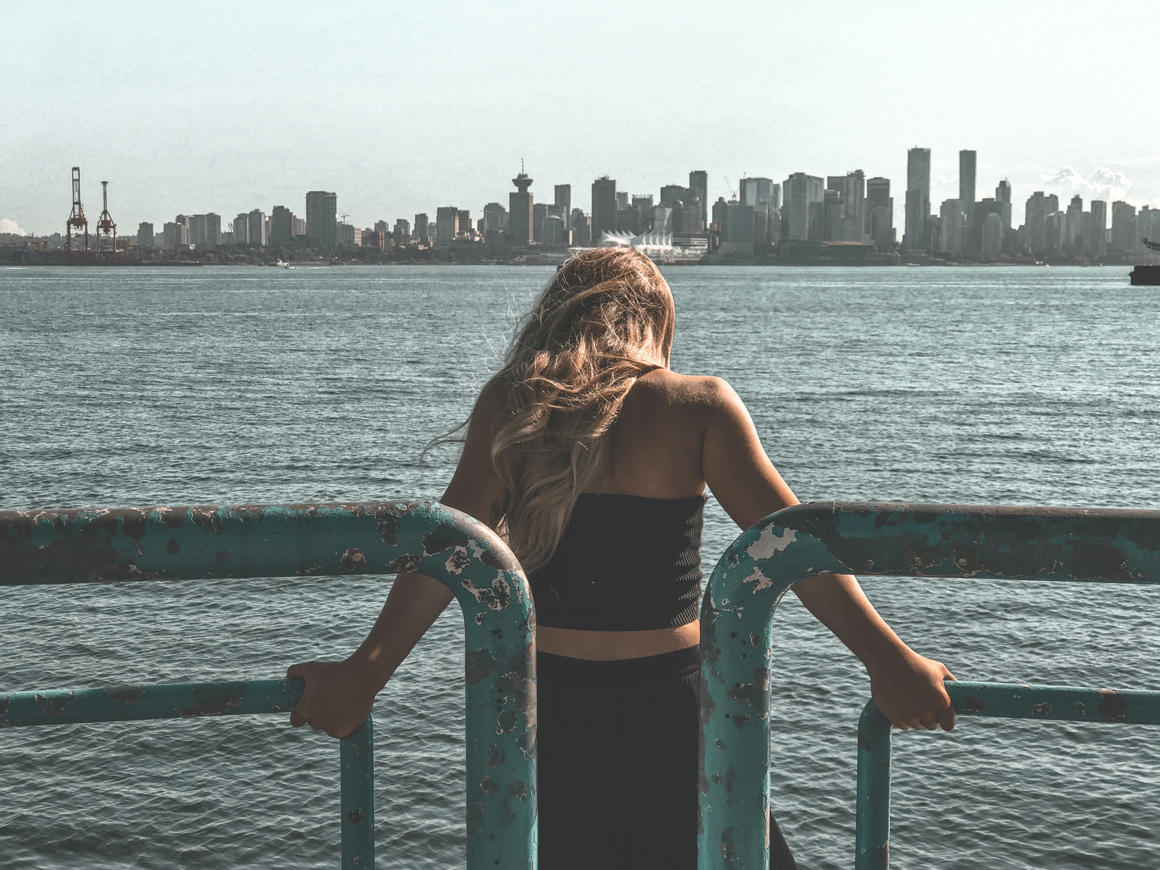 Harbor Front Portrait: A Woman at the Railing with the City Beyond