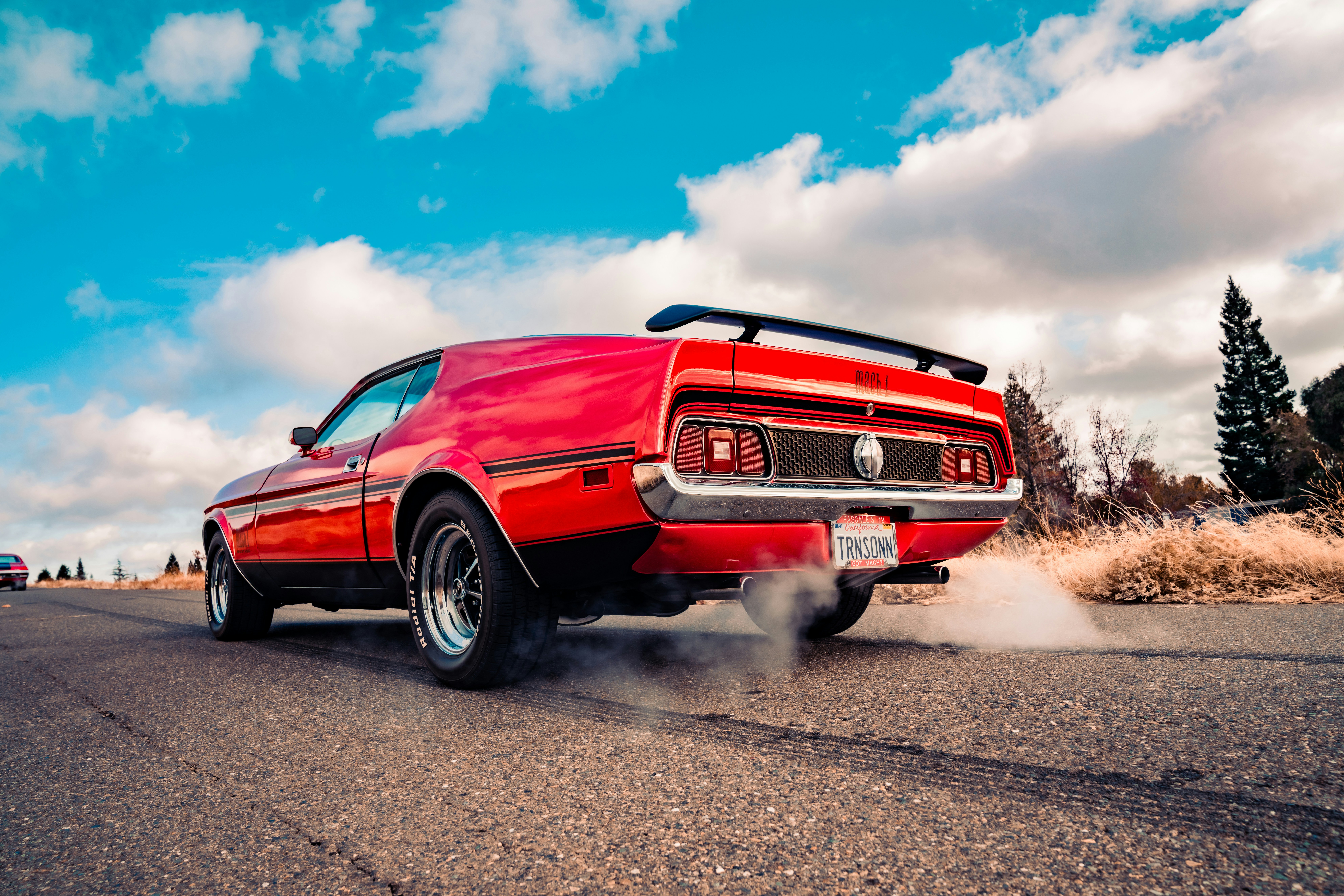 Chevrolet Camaro rouge sur une route asphaltée grise pendant la journée ...