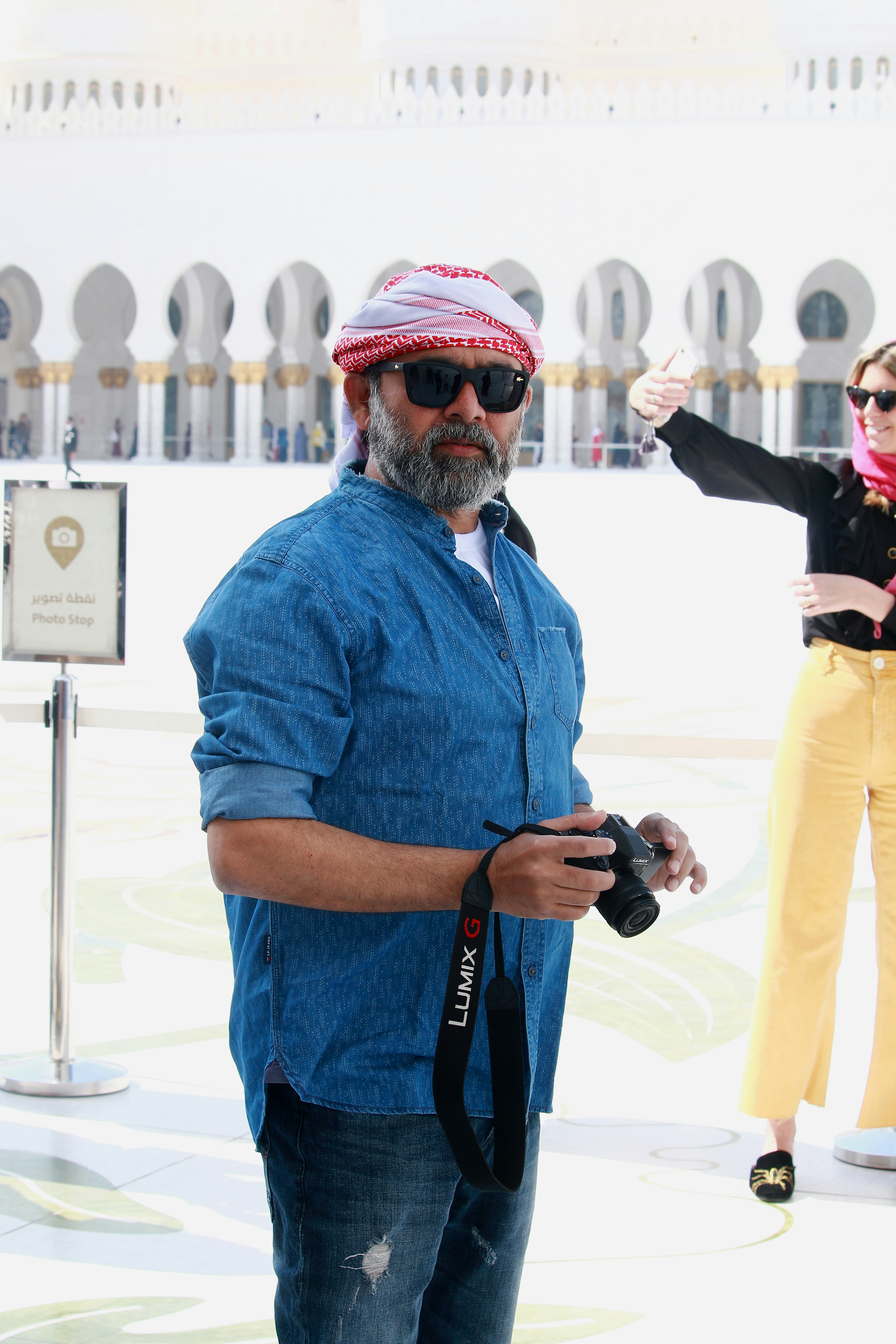 Bearded Photographer in a Sunlit Arcade of White Arches