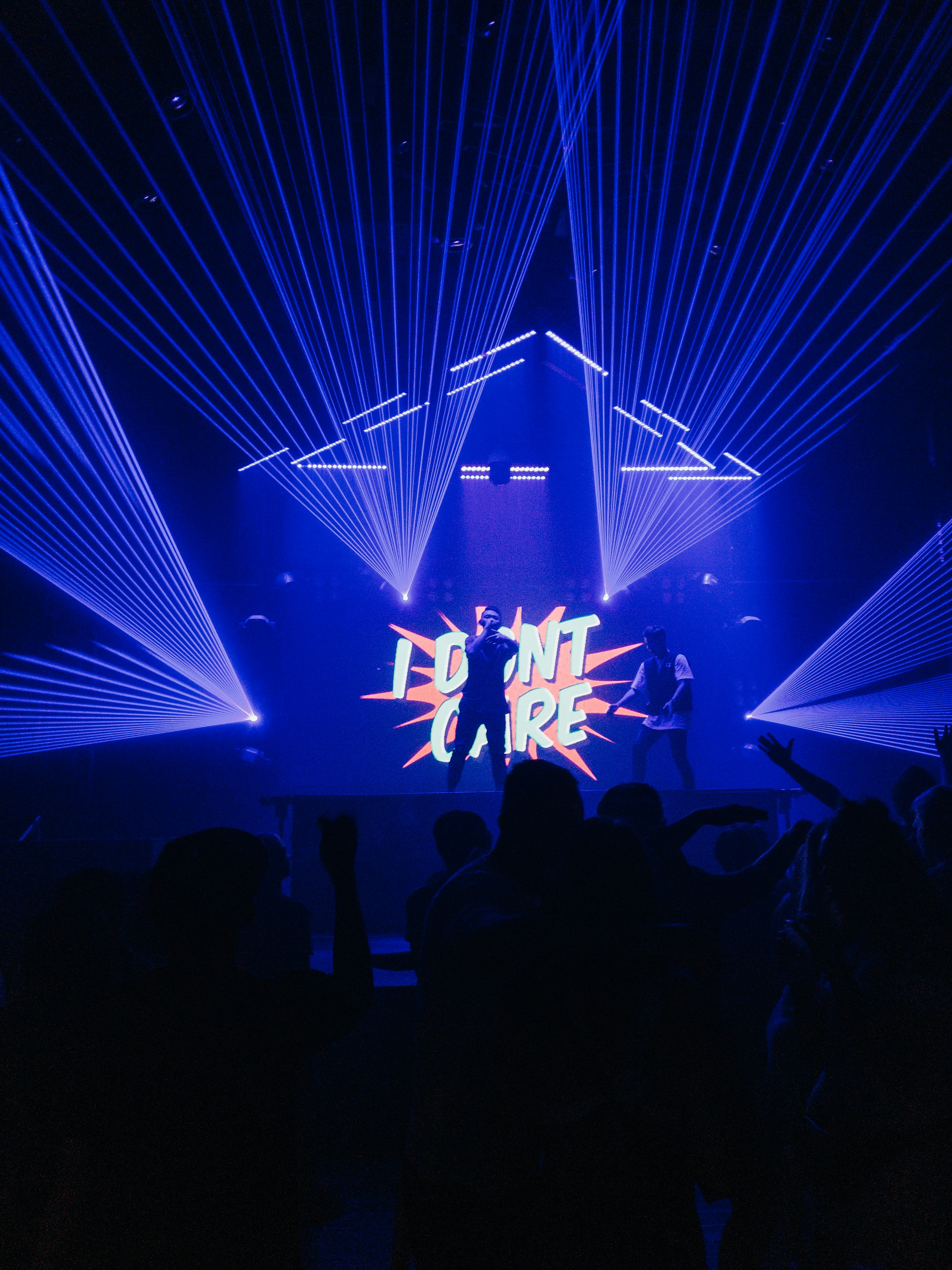 Center-Stage Neon Cascade: Lasers Sweep a Midnight Club Crowd