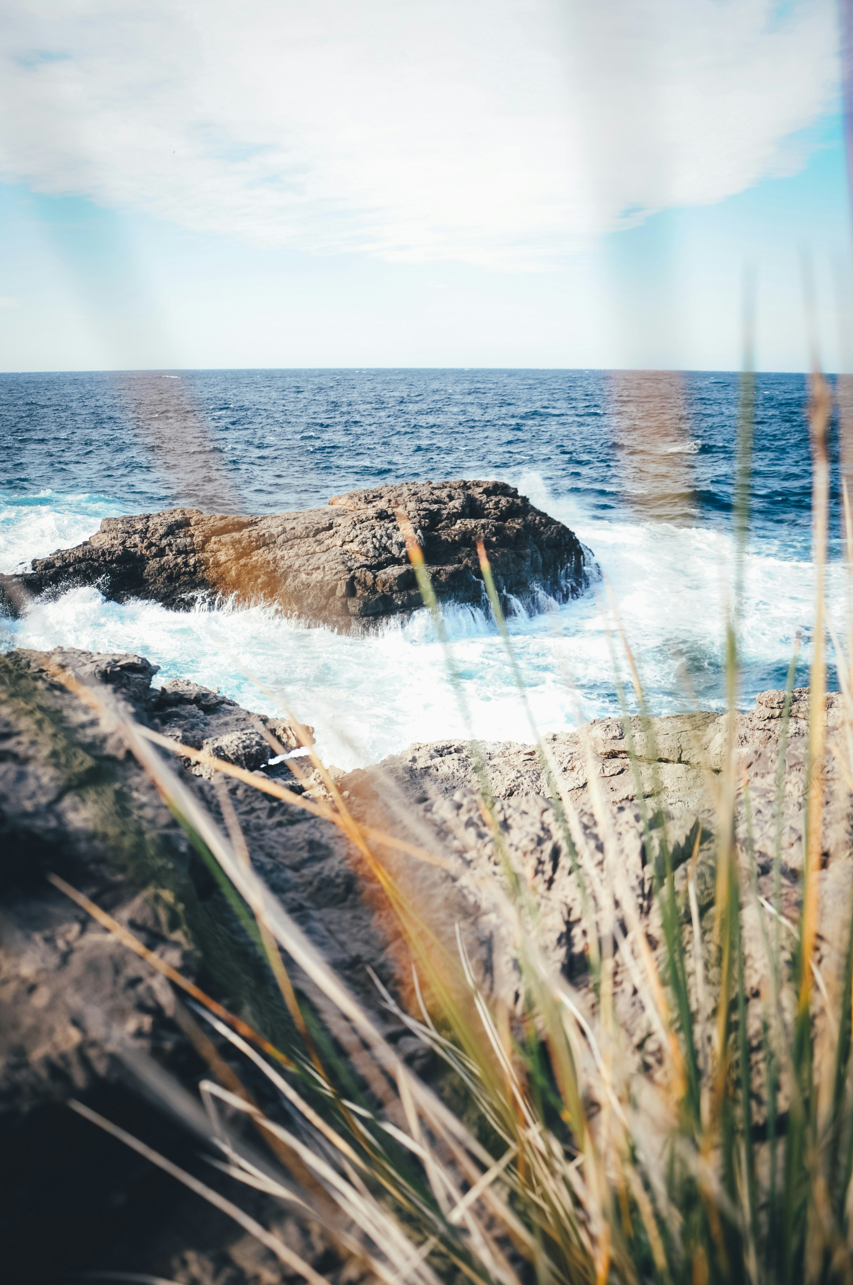 Rocky Outcrop at the Edge of the Tide, Framed by Coastal Grasses